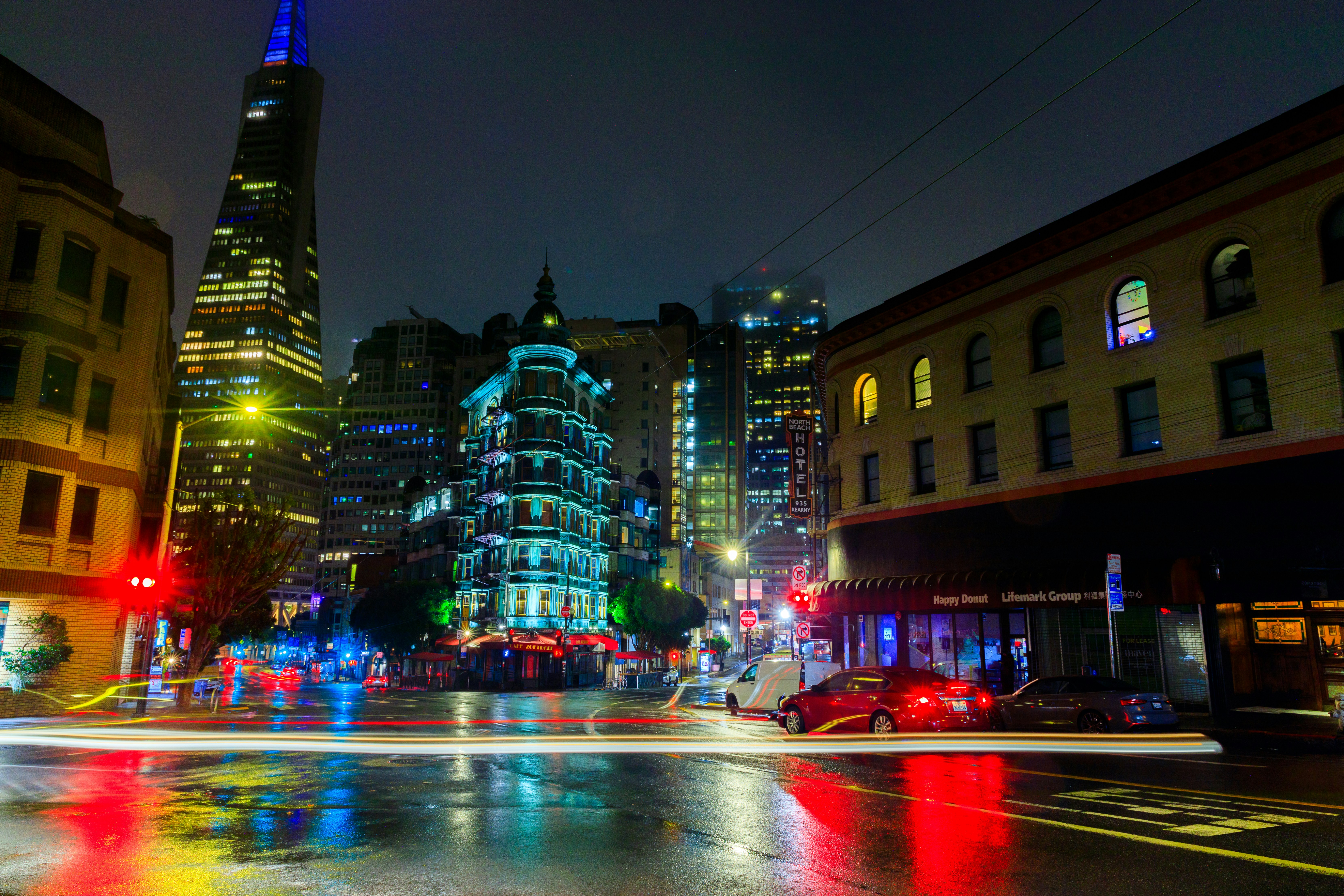Neon Crossroads: Nighttime Cityscape Under Rain-Slicked Streets