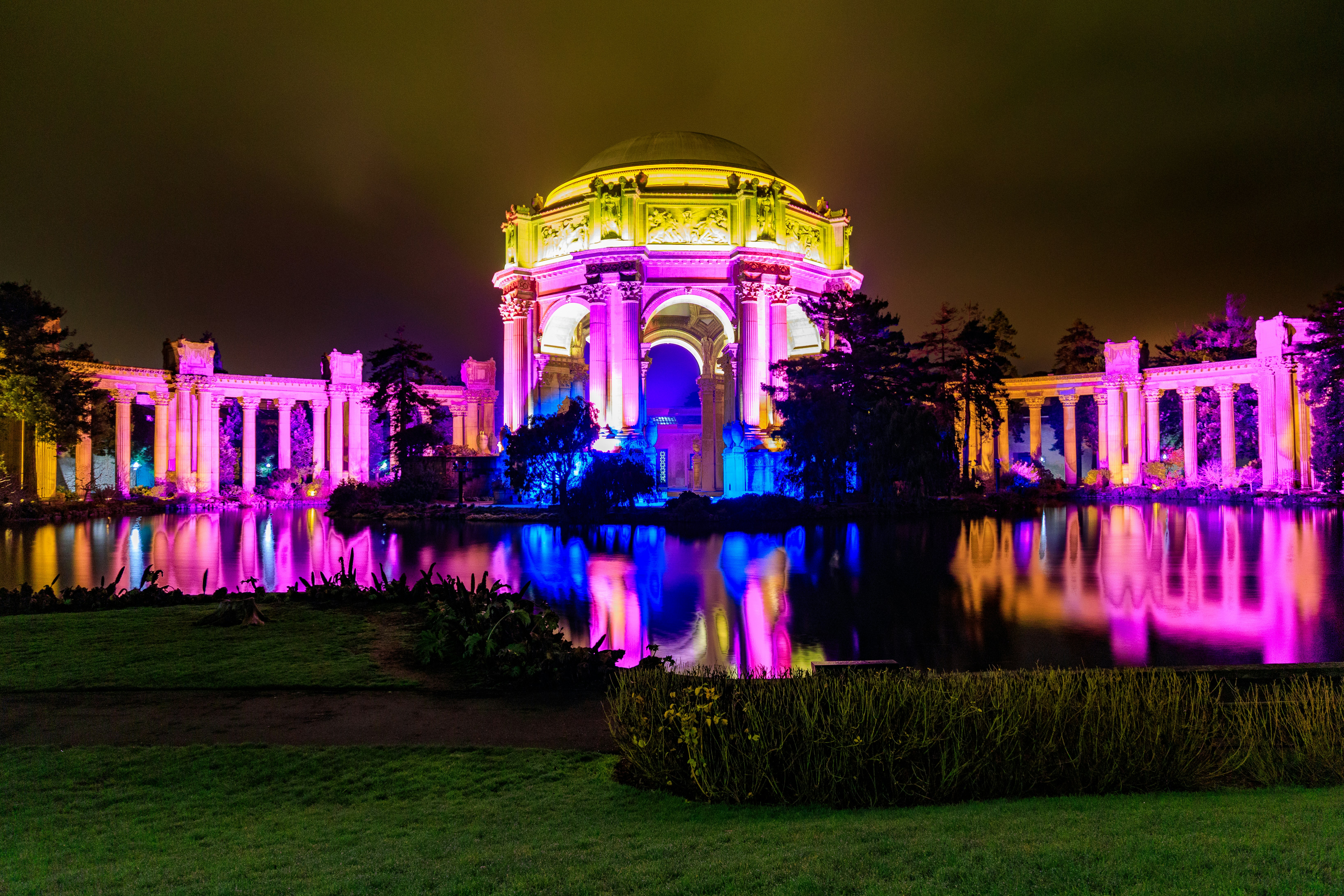 Illuminated Rotunda Nights: Neon Reflections over a Terraced Arcade