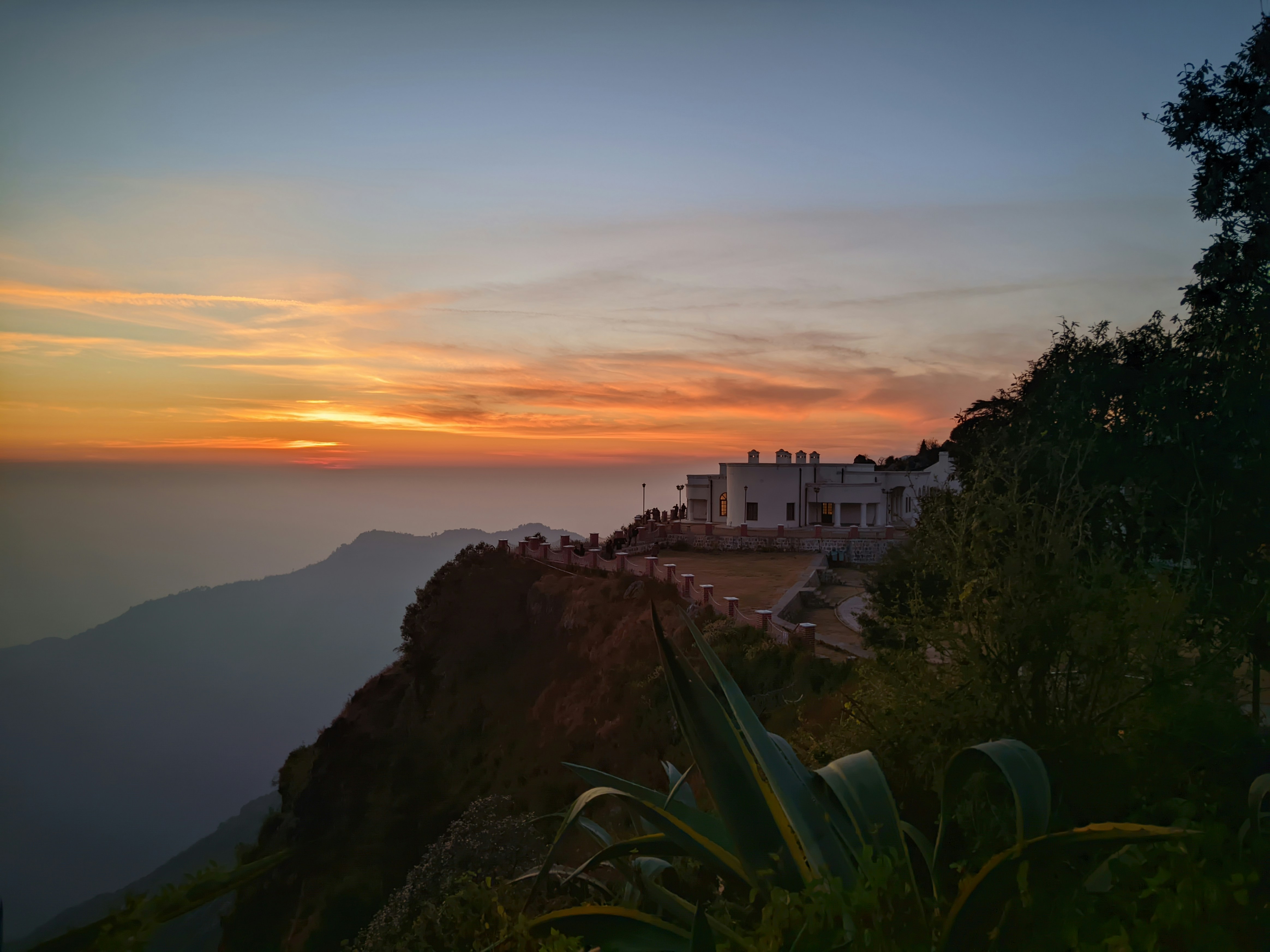 Sunset over a mountain landscape with buildings.