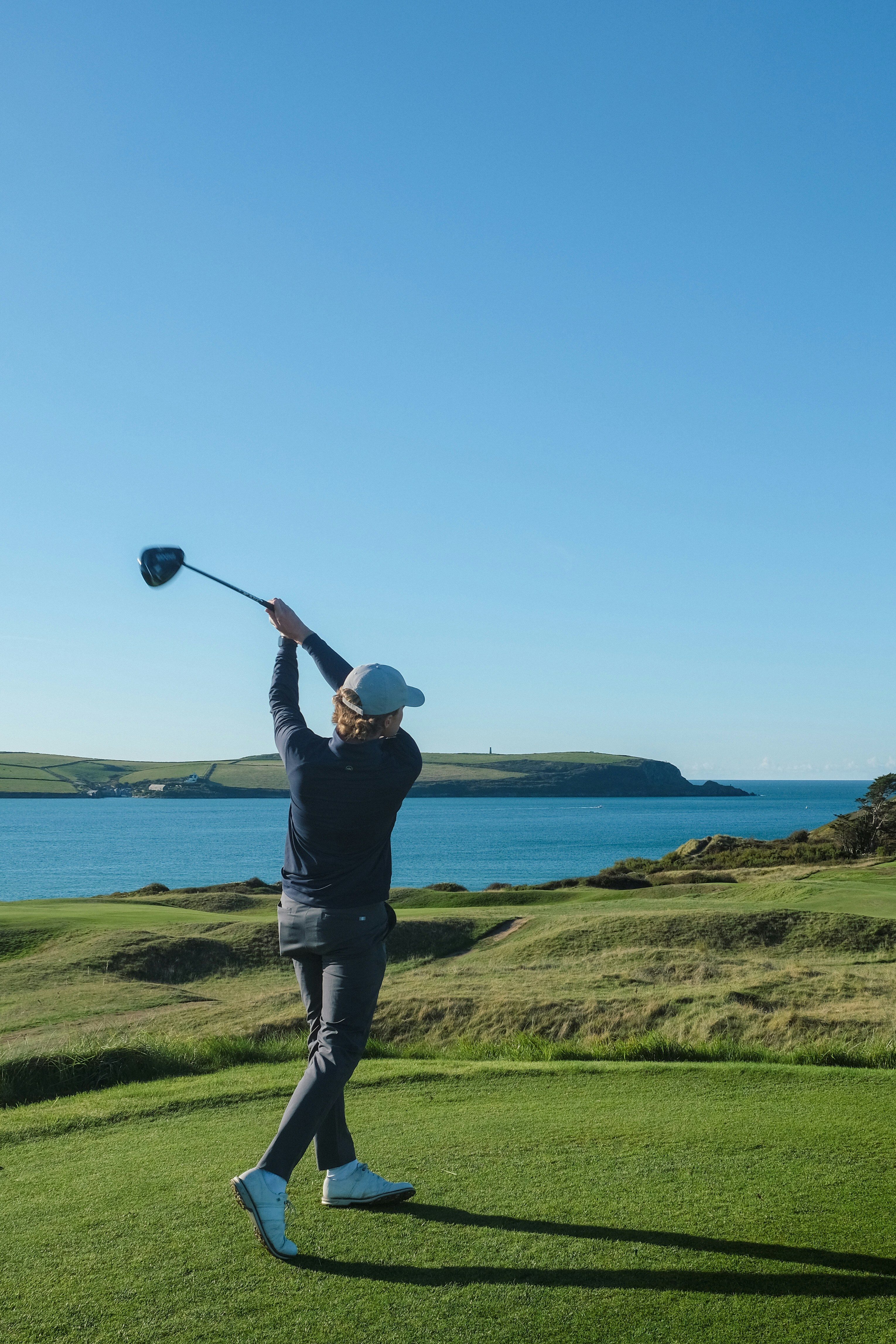 Swinging toward the Sea: A golfer’s moment on a sunlit coastal course