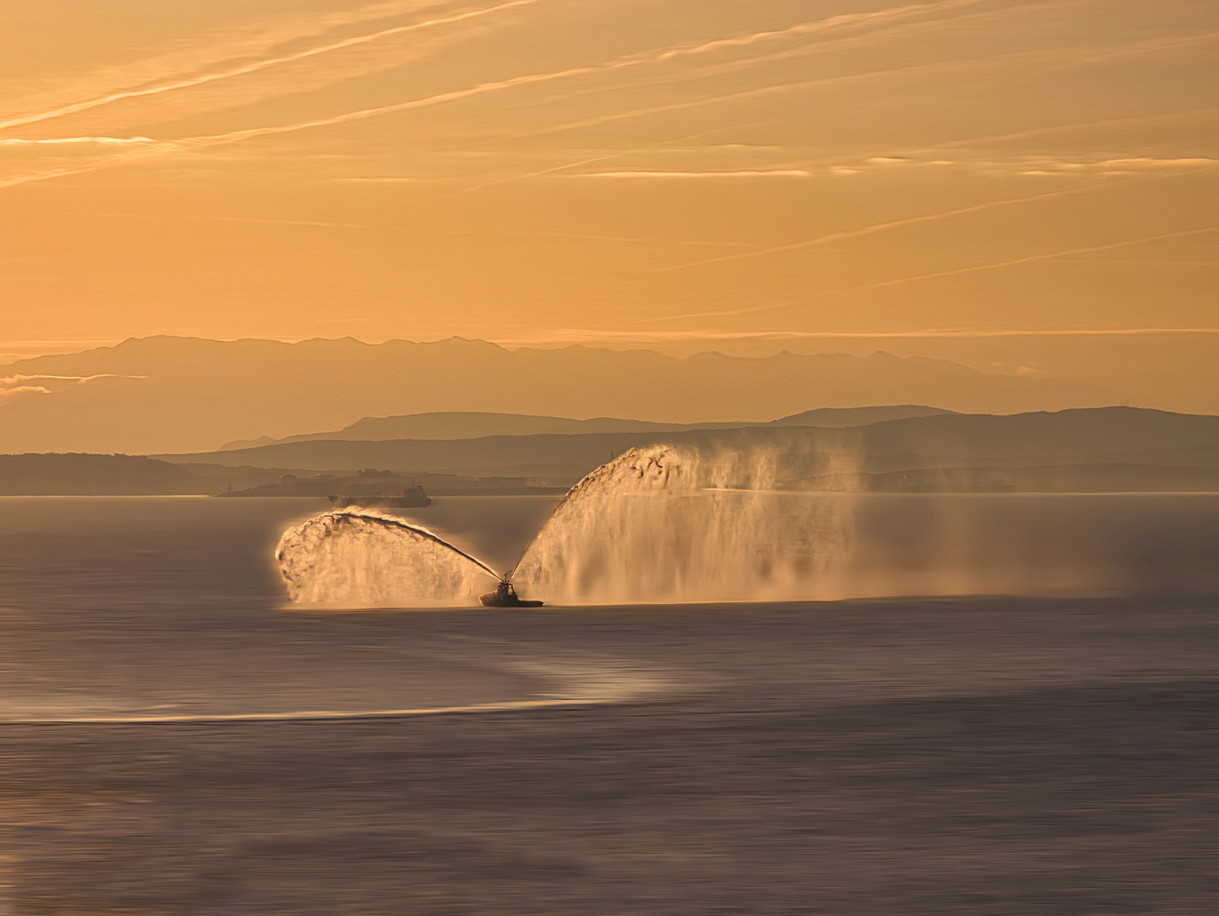 Sunlit Whale Tail Spray Breaks the Horizon