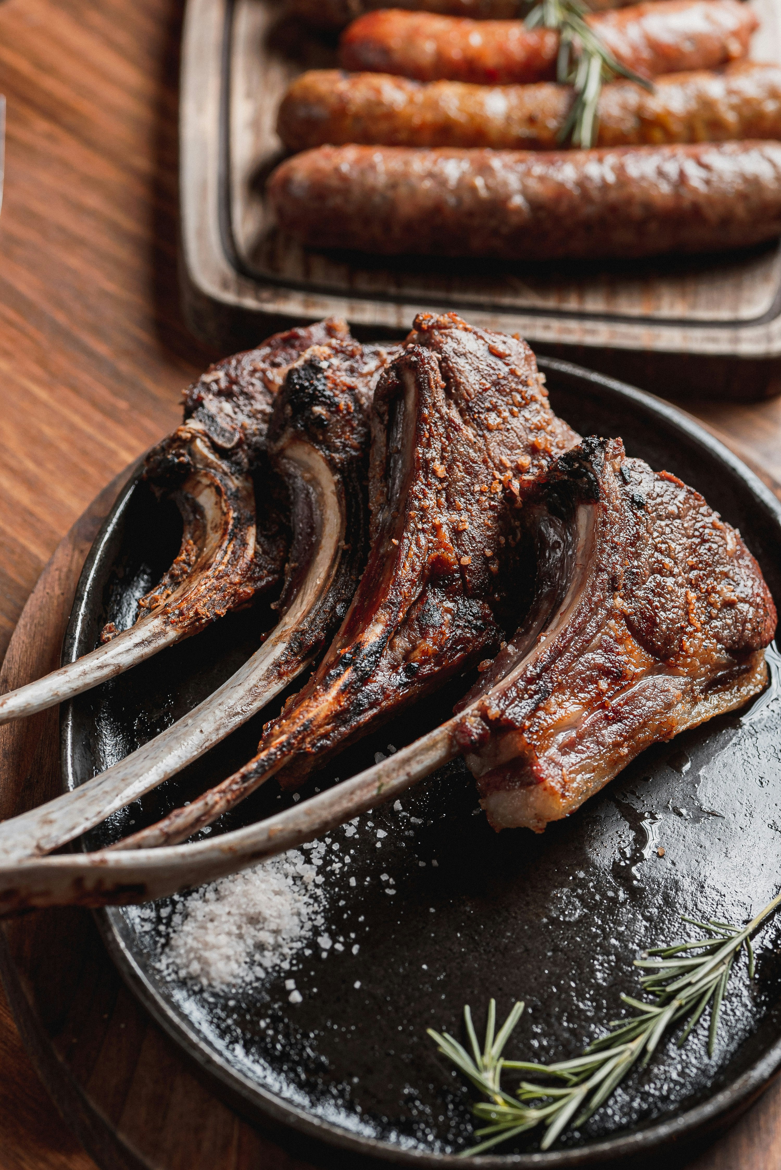 Grilled lamb chops with sausages on wooden table. photo – Free Food ...