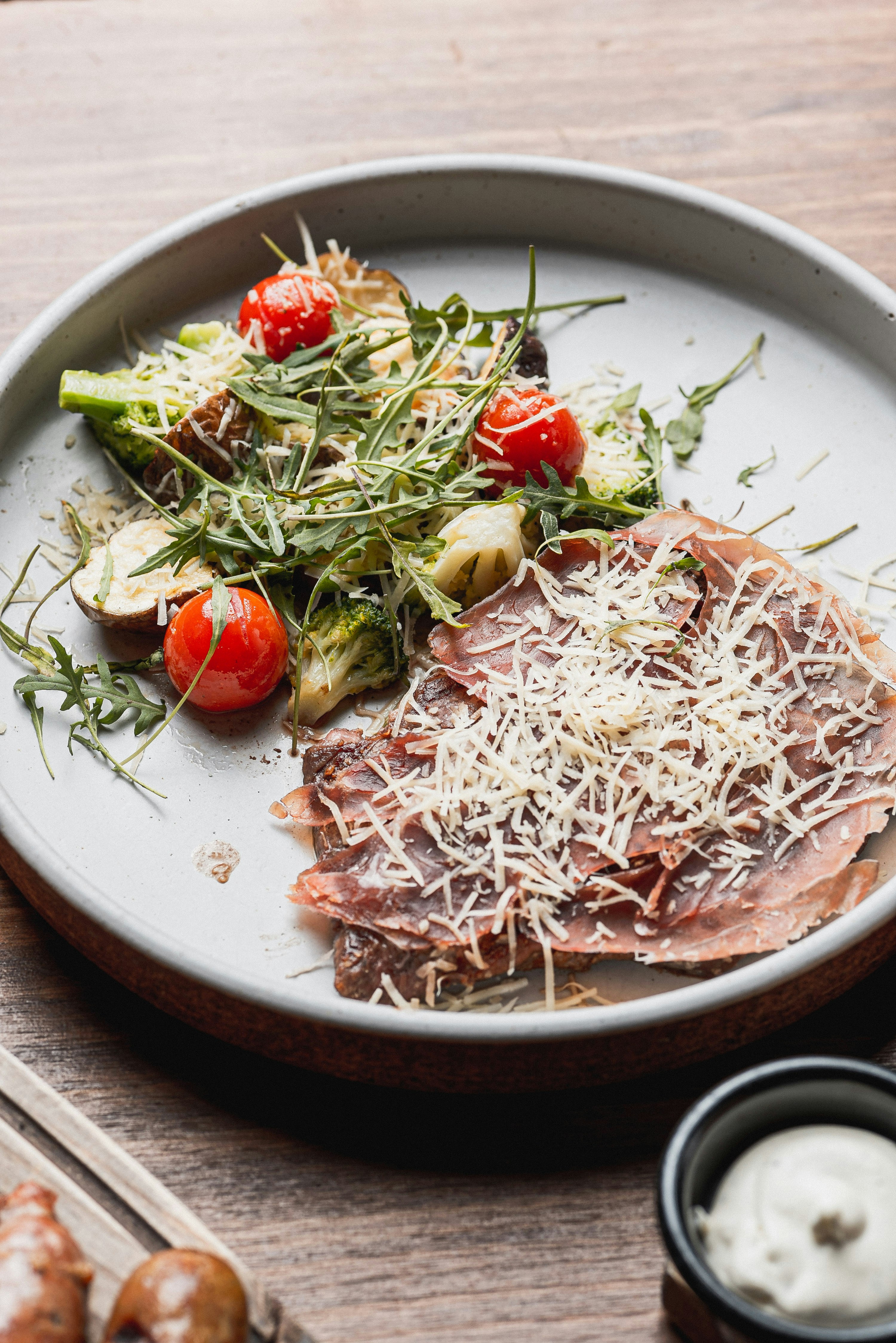 Herbed Roast with Shredded Cheese and Charred Vegetables on a Skillet Plate