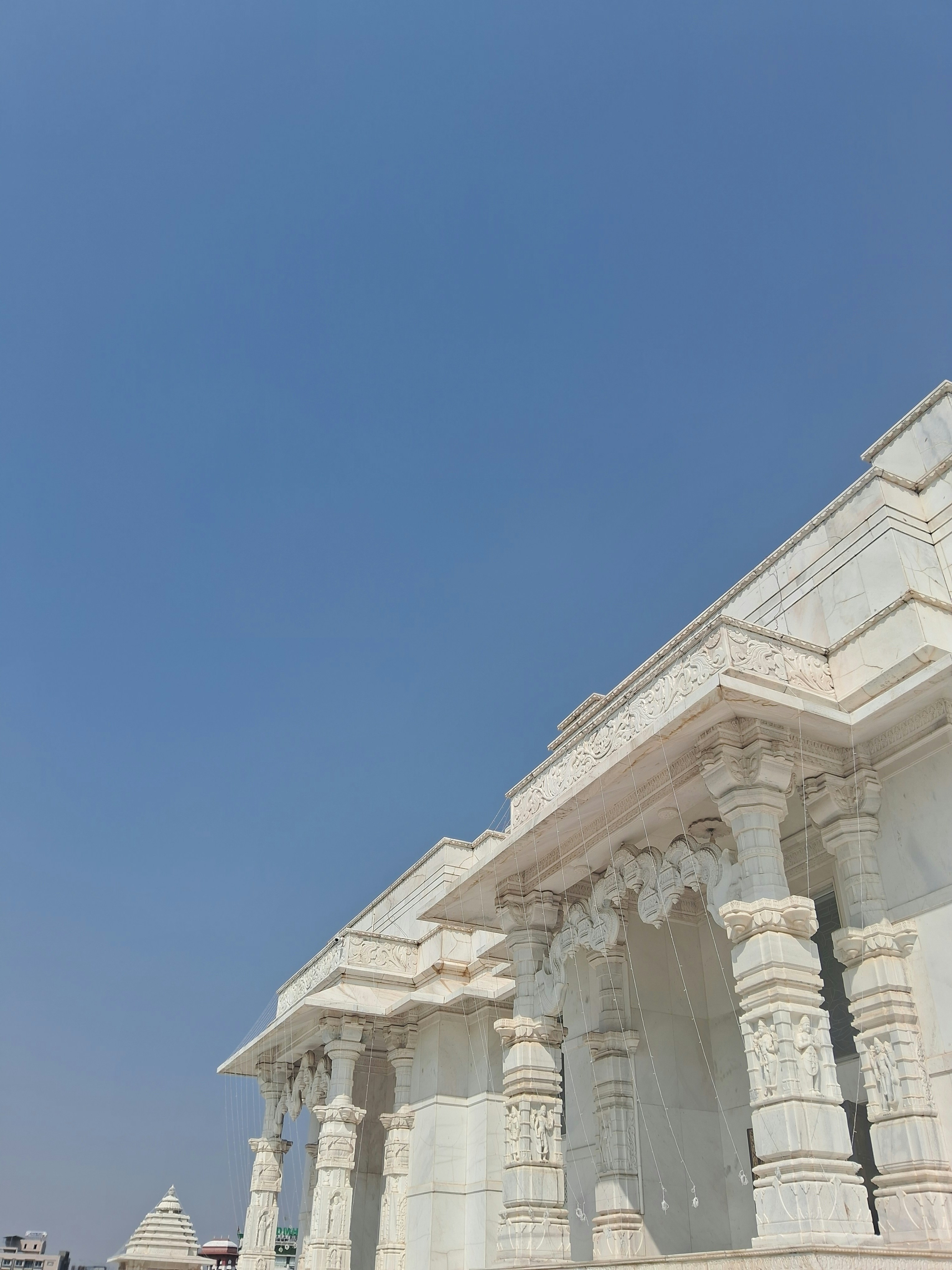 White marble temple architecture against a clear blue sky.