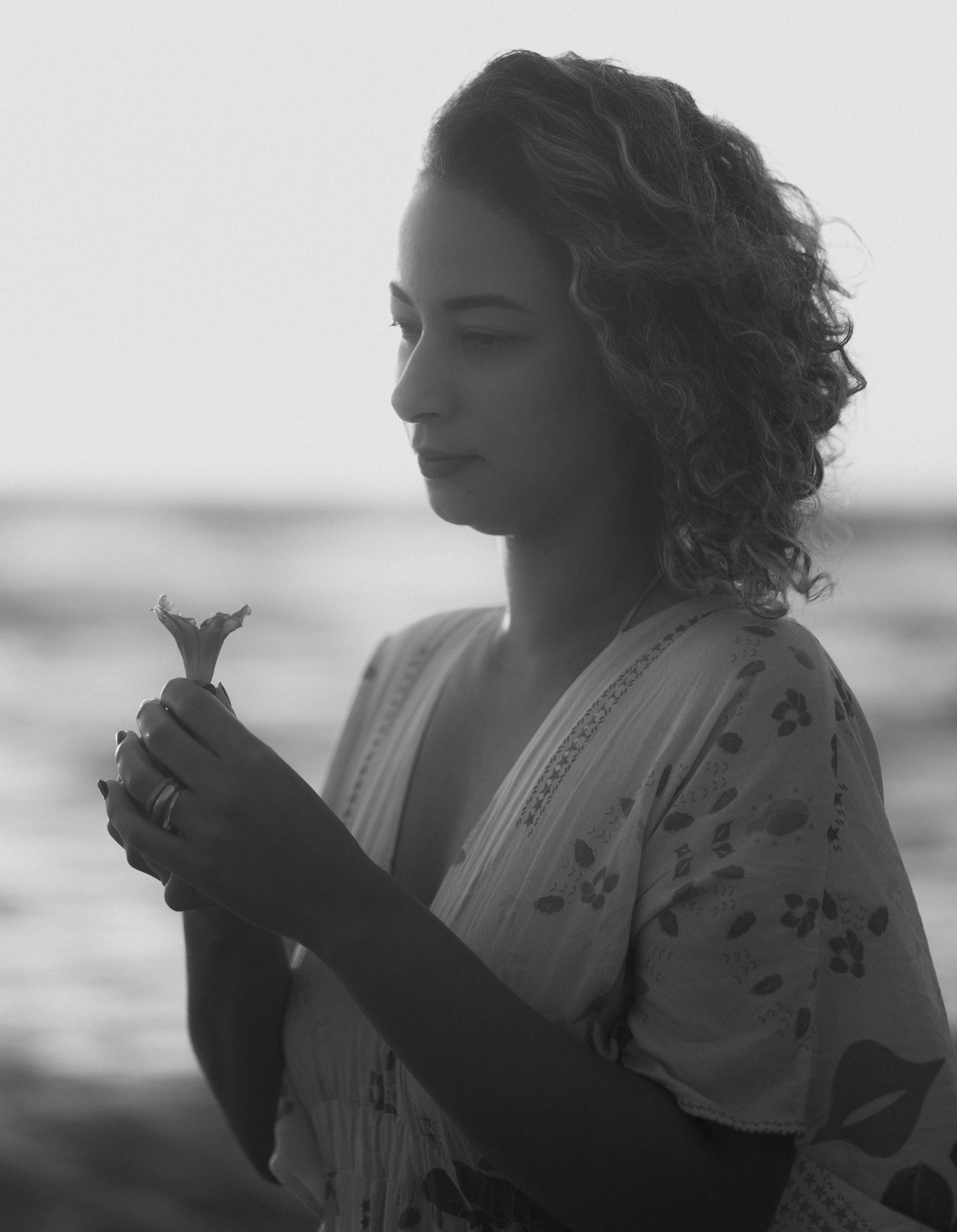 Quiet Resolve: A Seaside Moment with a Delicate Bloom