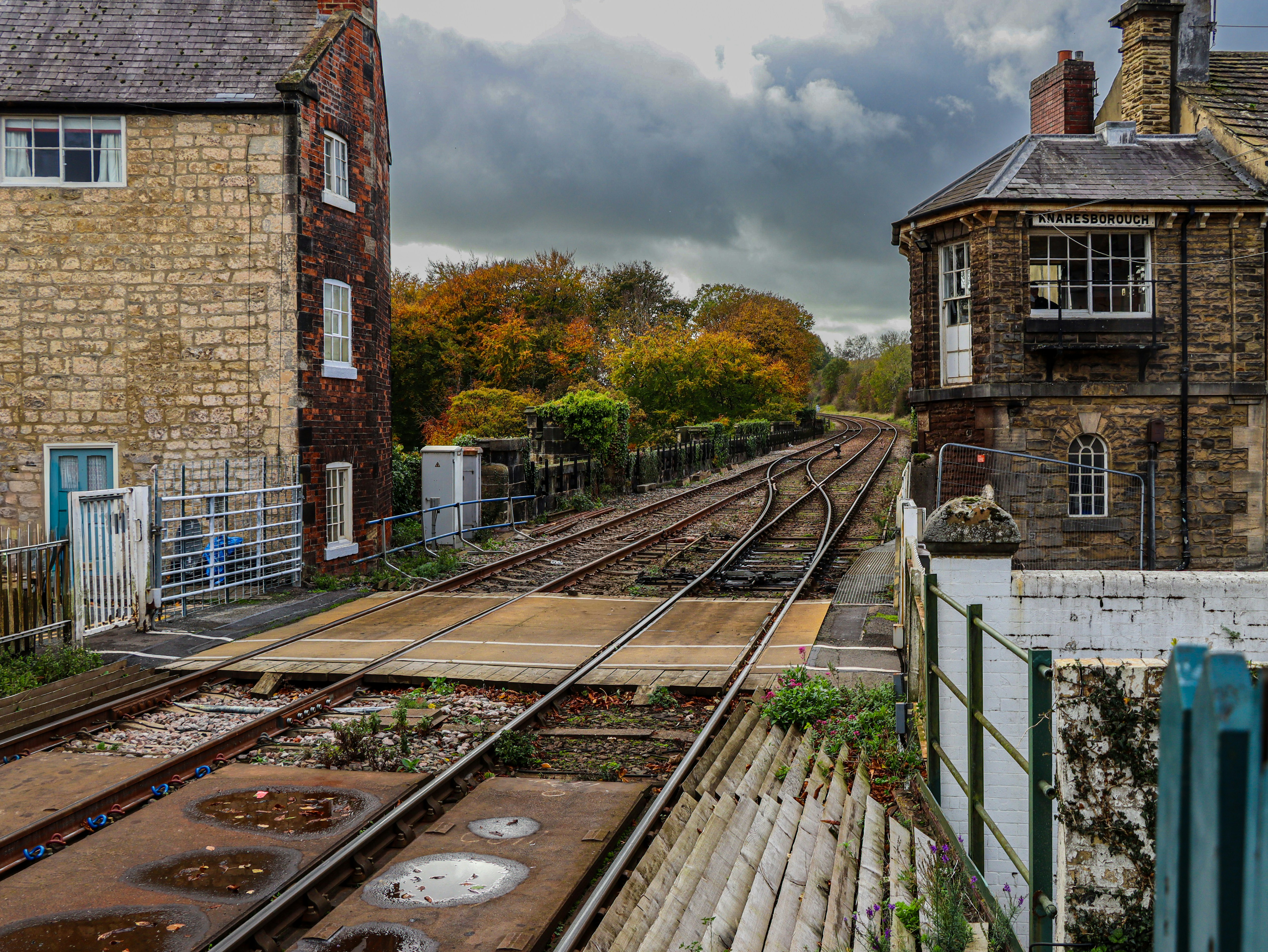 Tracks at Dusk: A Quiet Crossing Between Brick Buildings