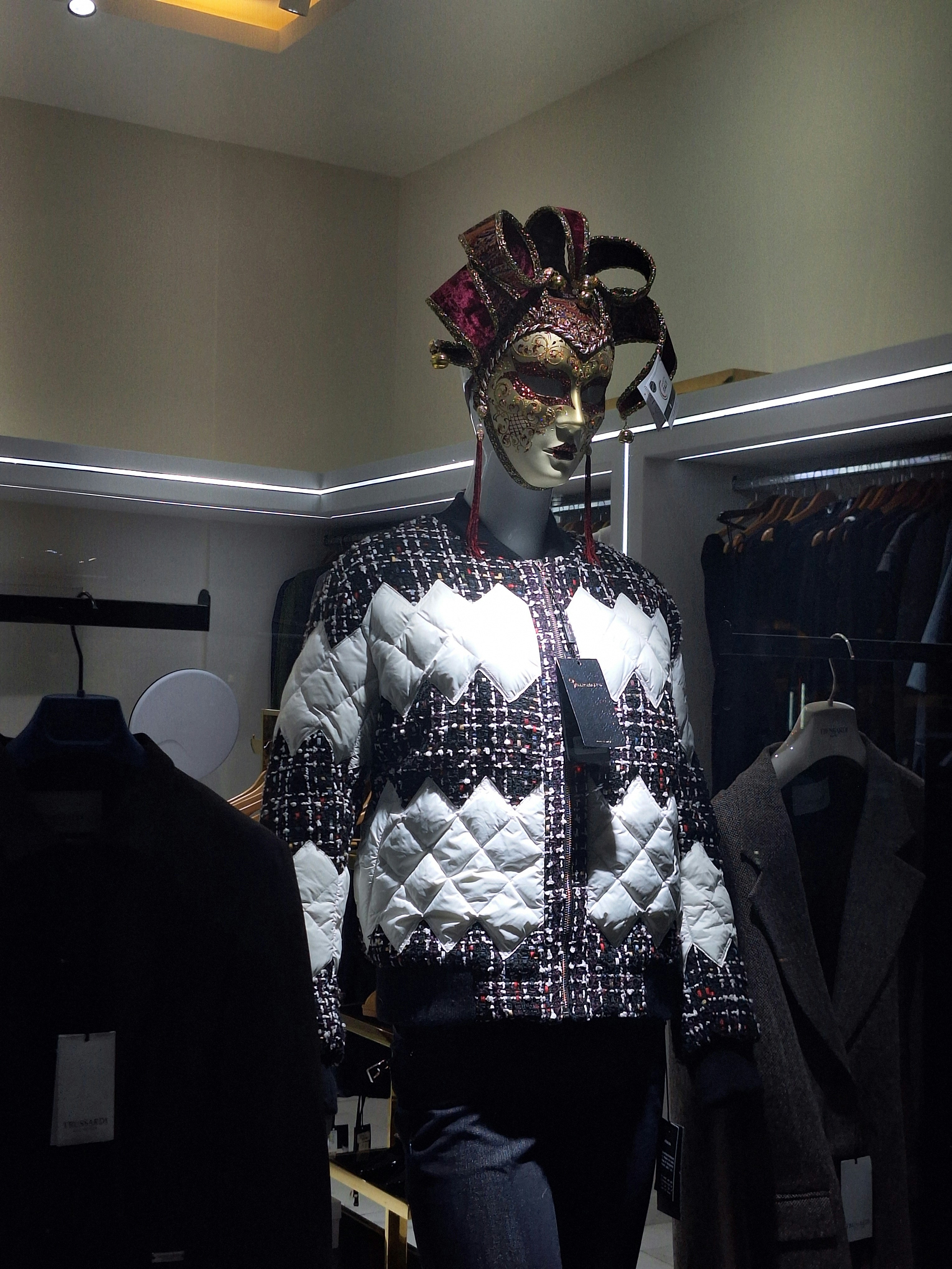 Masked mannequin in a designer boutique displays geometric quilting jacket