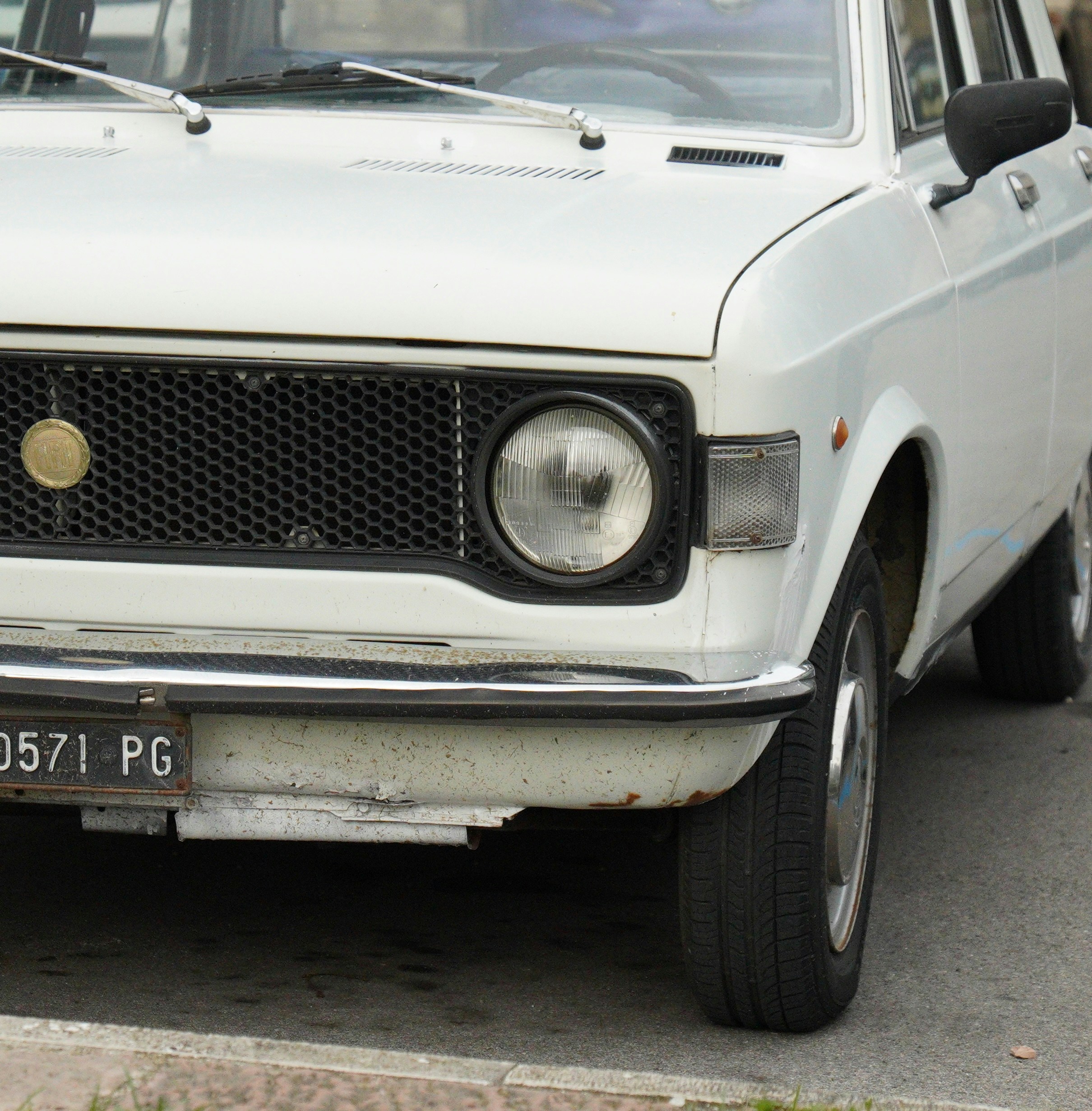 Dusty white classic: the front-left of a vintage sedan