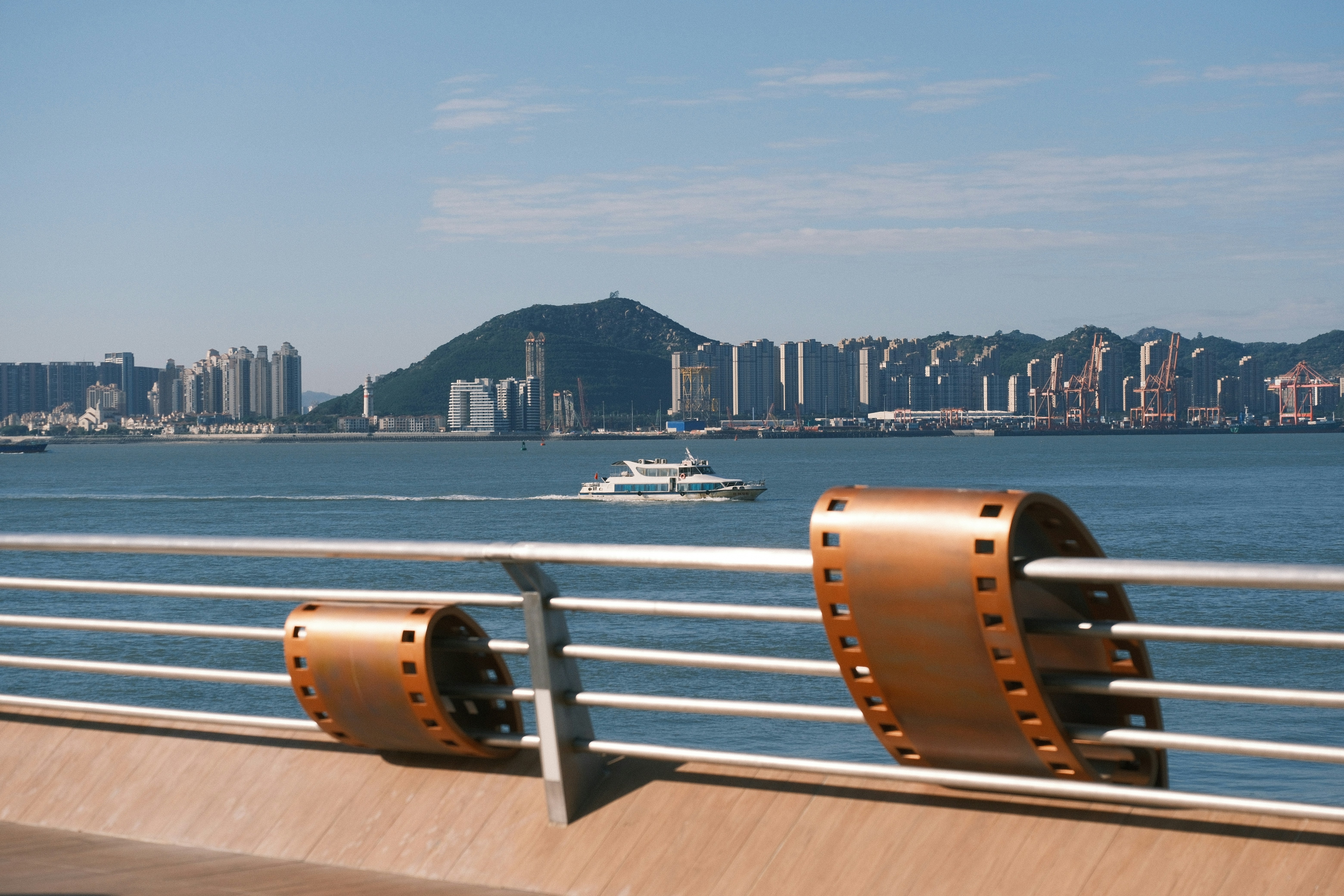 Copper-Toned Rail Clamps Framing a Coastal Skyline
