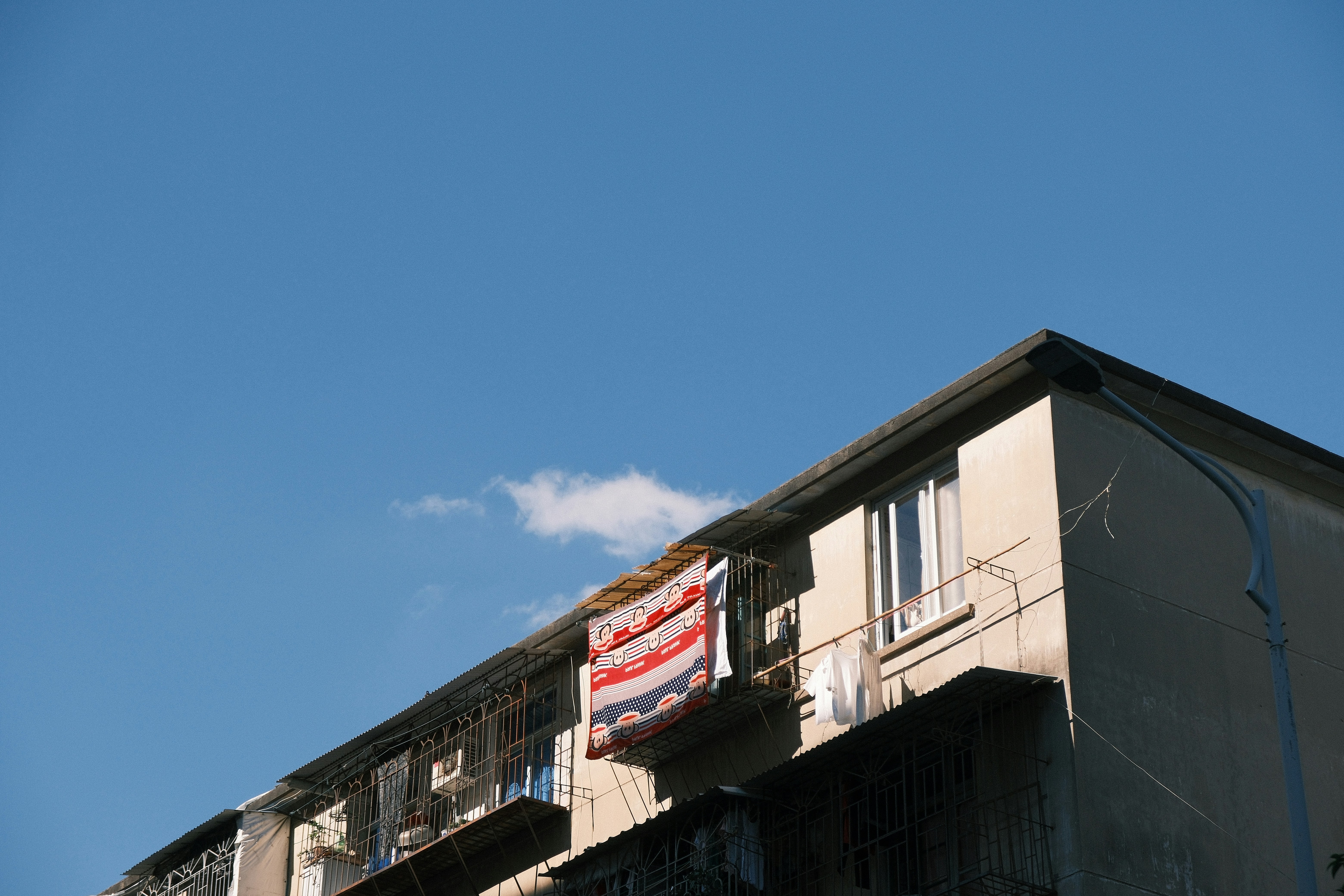 Edge of the Building: balcony clutter under a clear blue sky