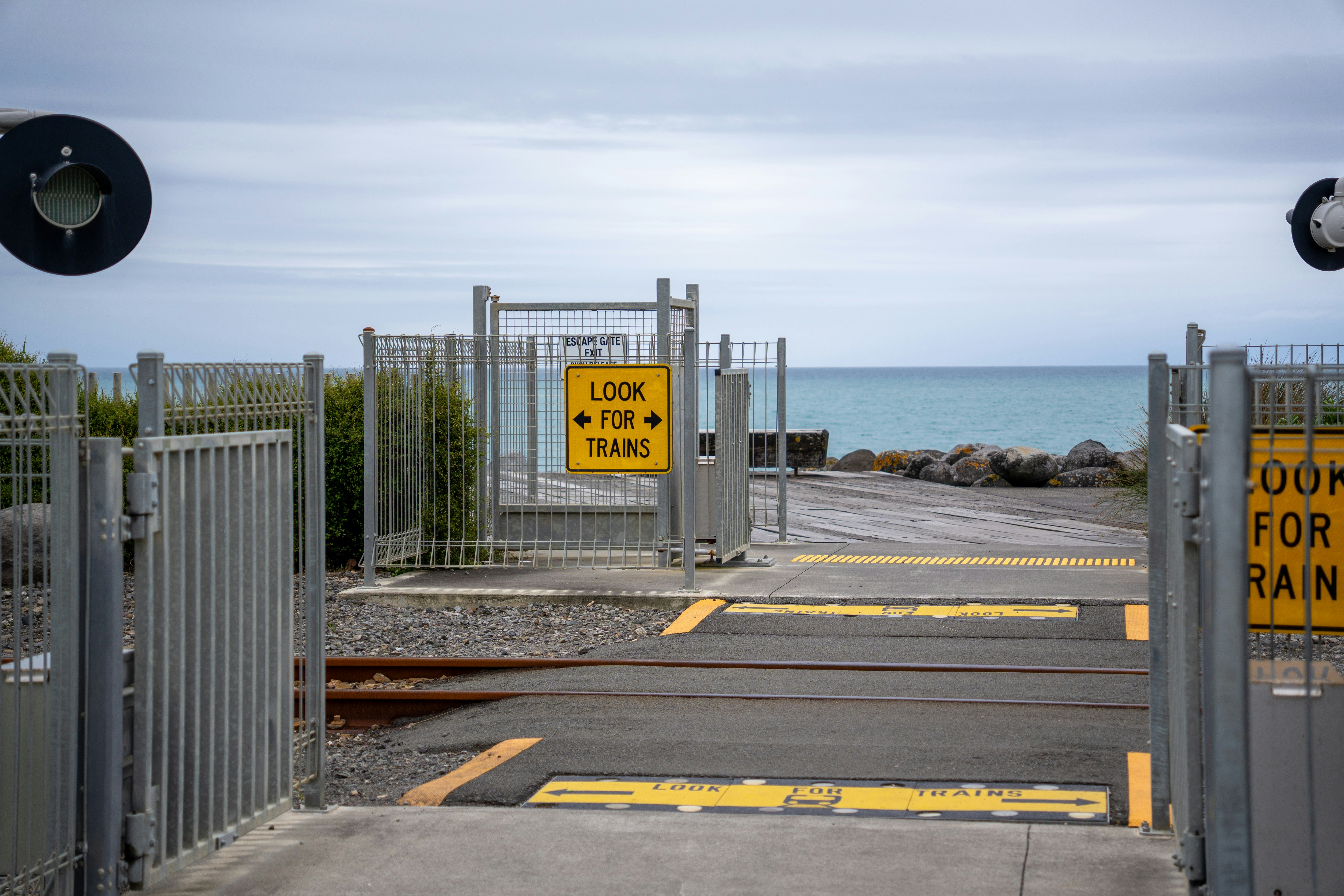 Train crossing with ocean view and warning signs photo – Free Beach ...