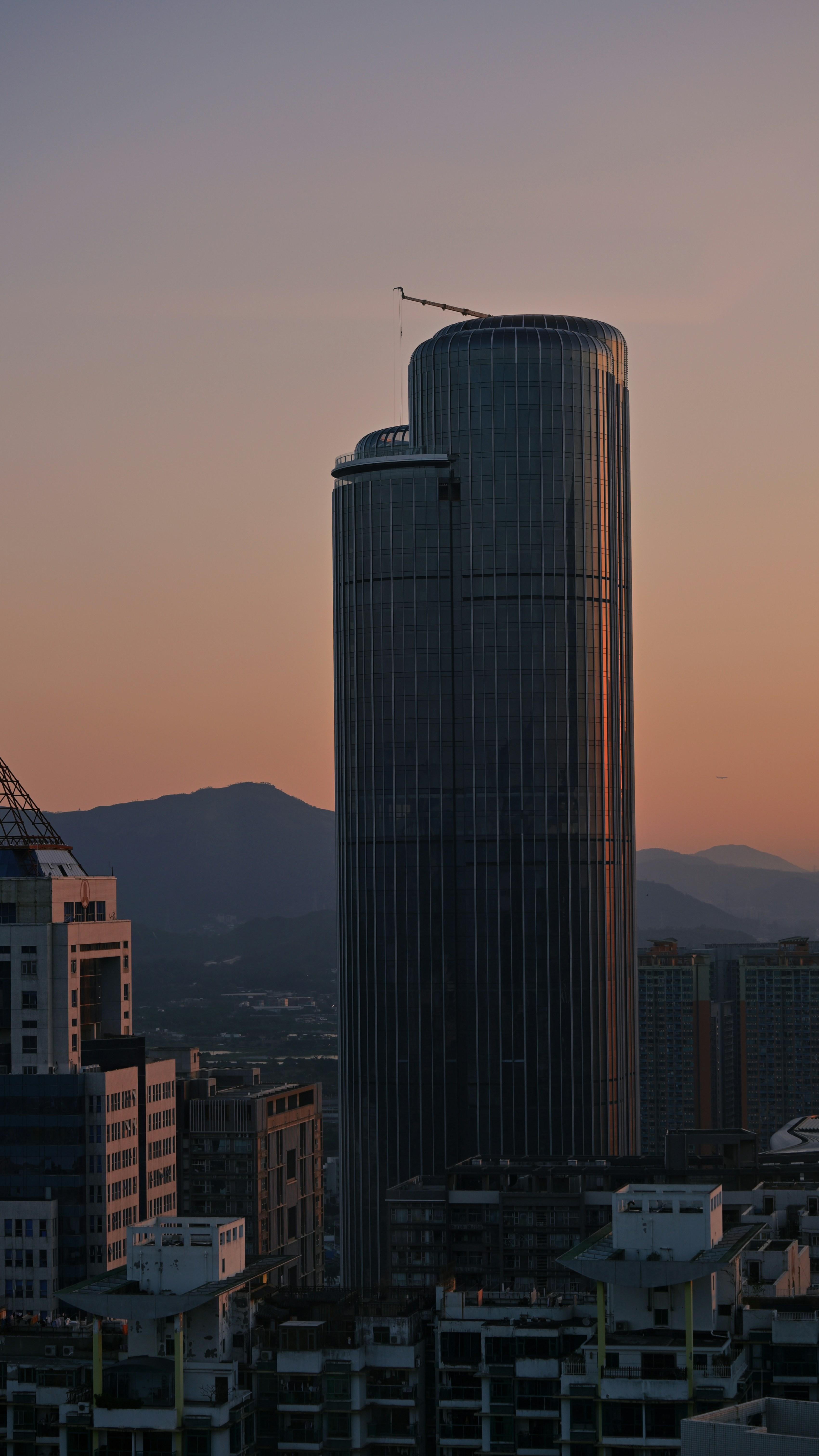 Sunset Skyline: The Cylindrical Tower Reaching Toward the Last Light