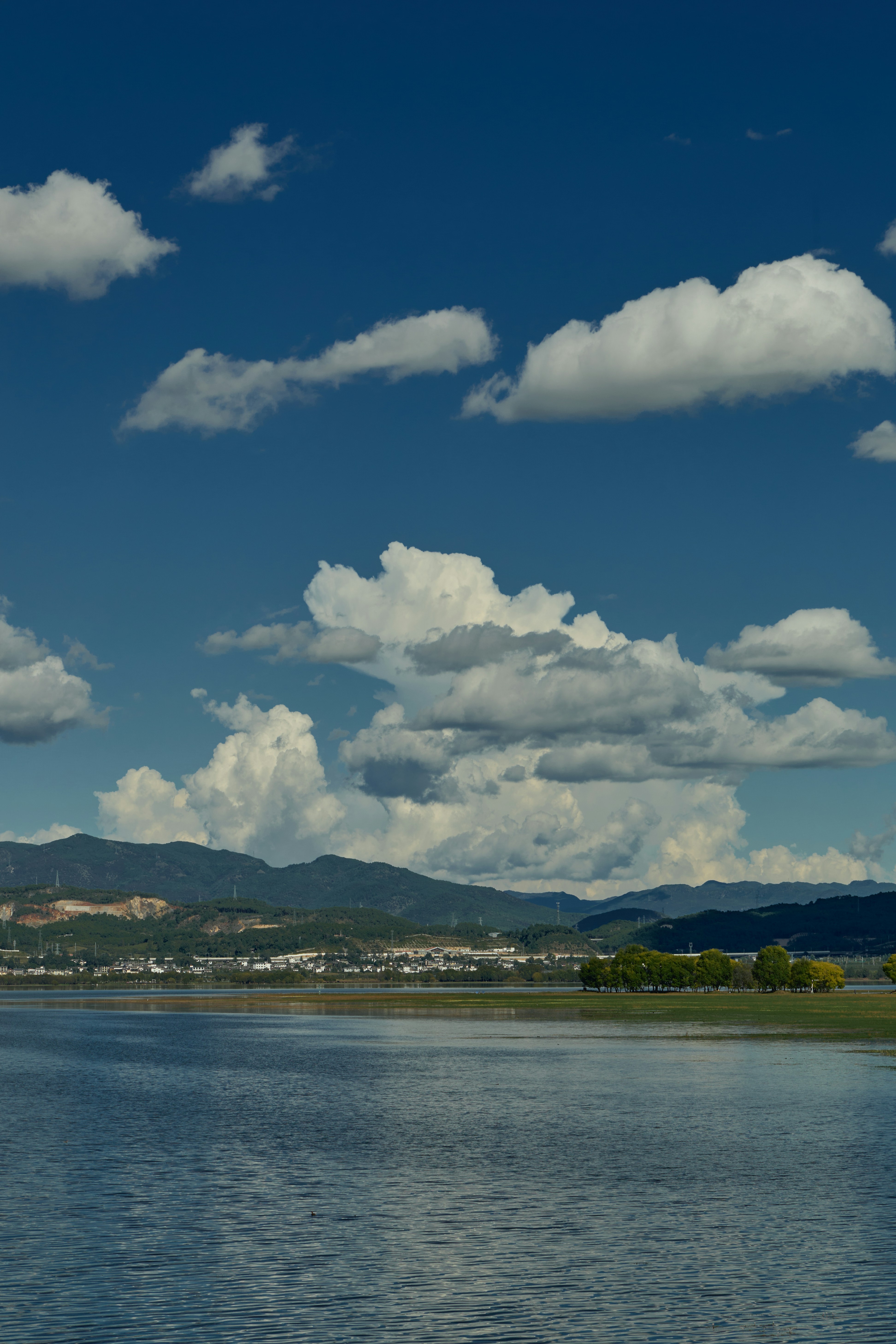 Cloud-swept lake beside distant foothills