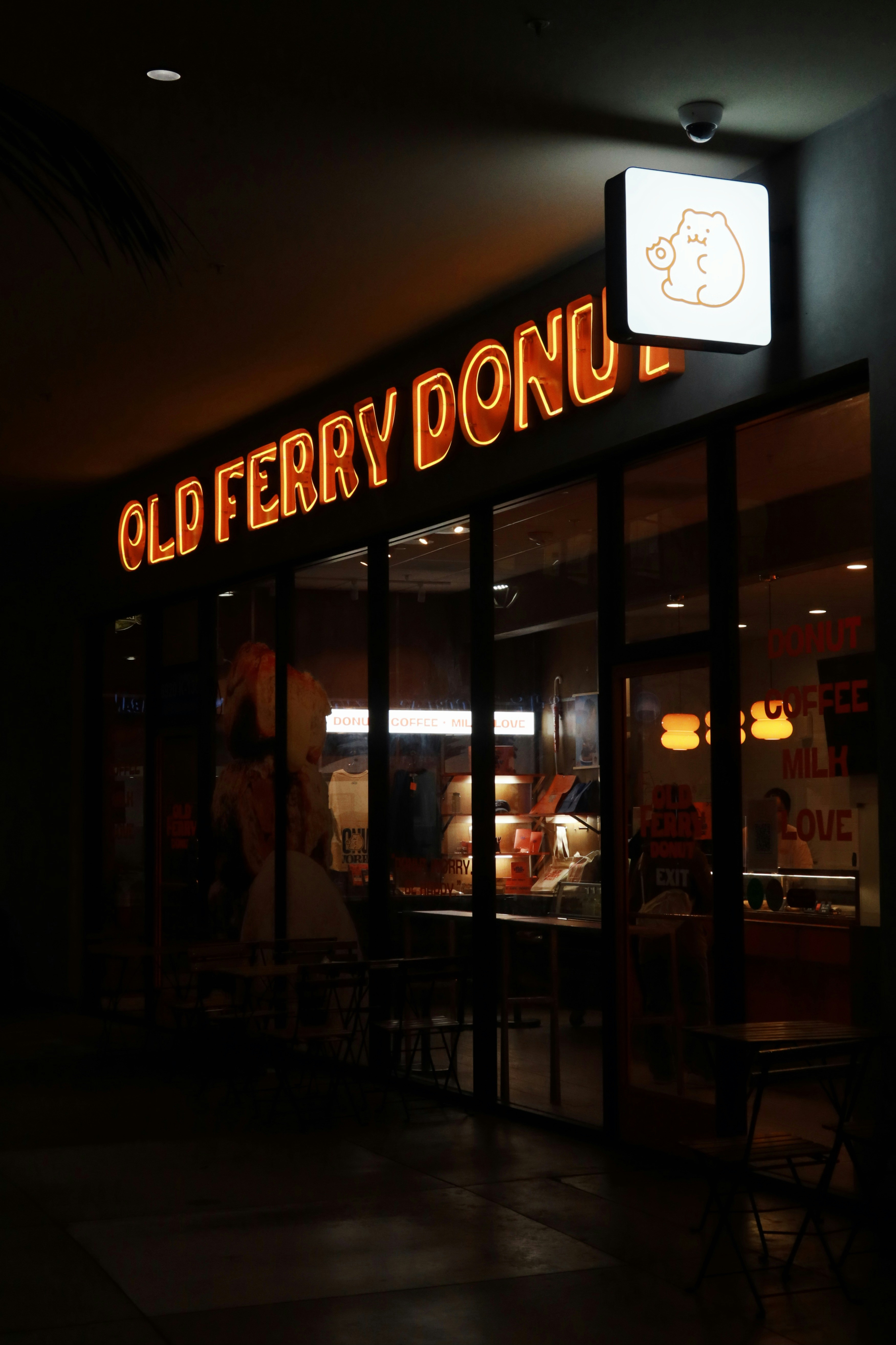 Neon Old Ferry Donuts: Warm Light Inside a Nighttime Café