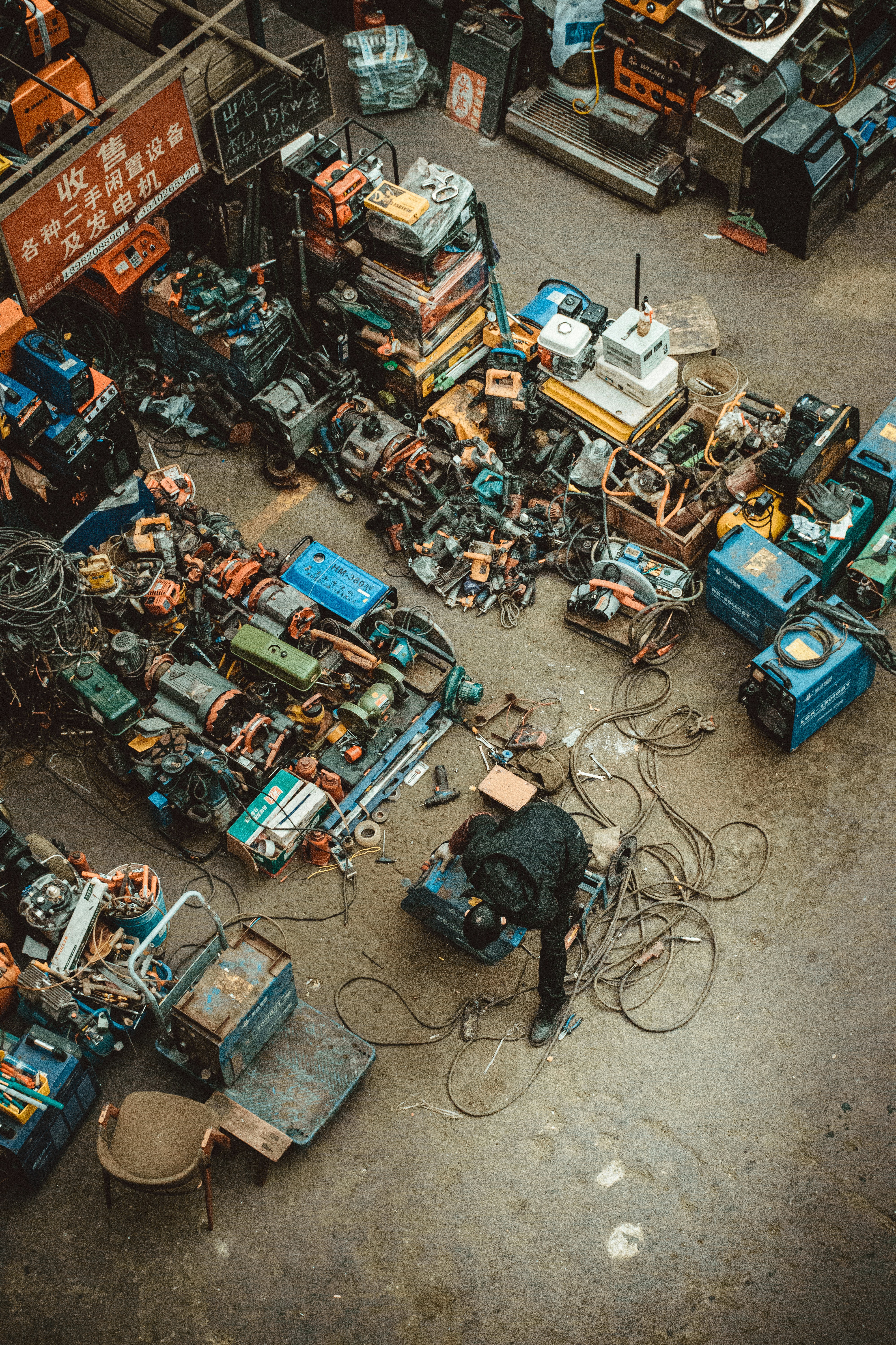 Overhead Clutter: A Jumble of Tools and Machinery In a Workshop Yard