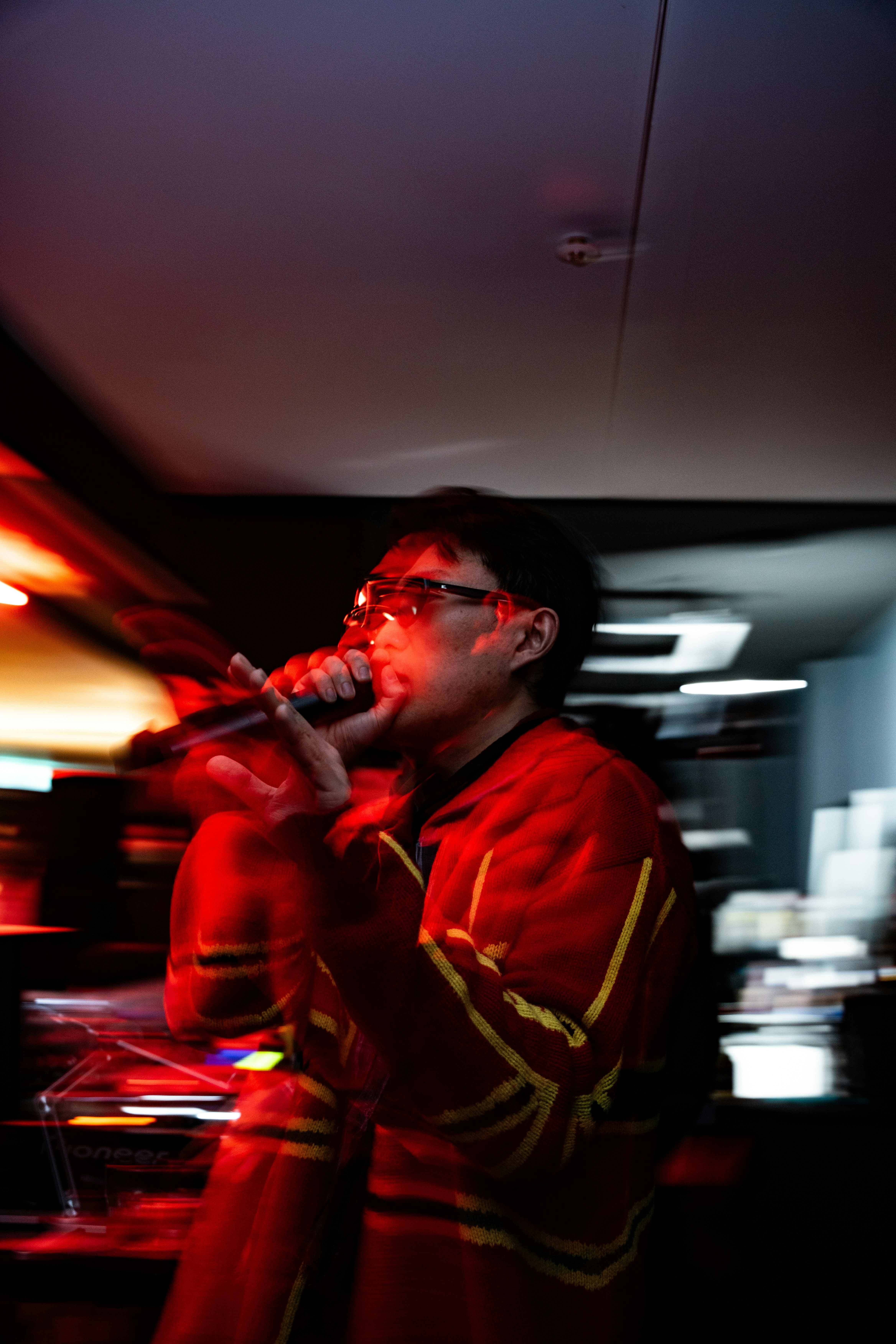 Red-lit Spotlight: A Live MC Enveloped in Motion