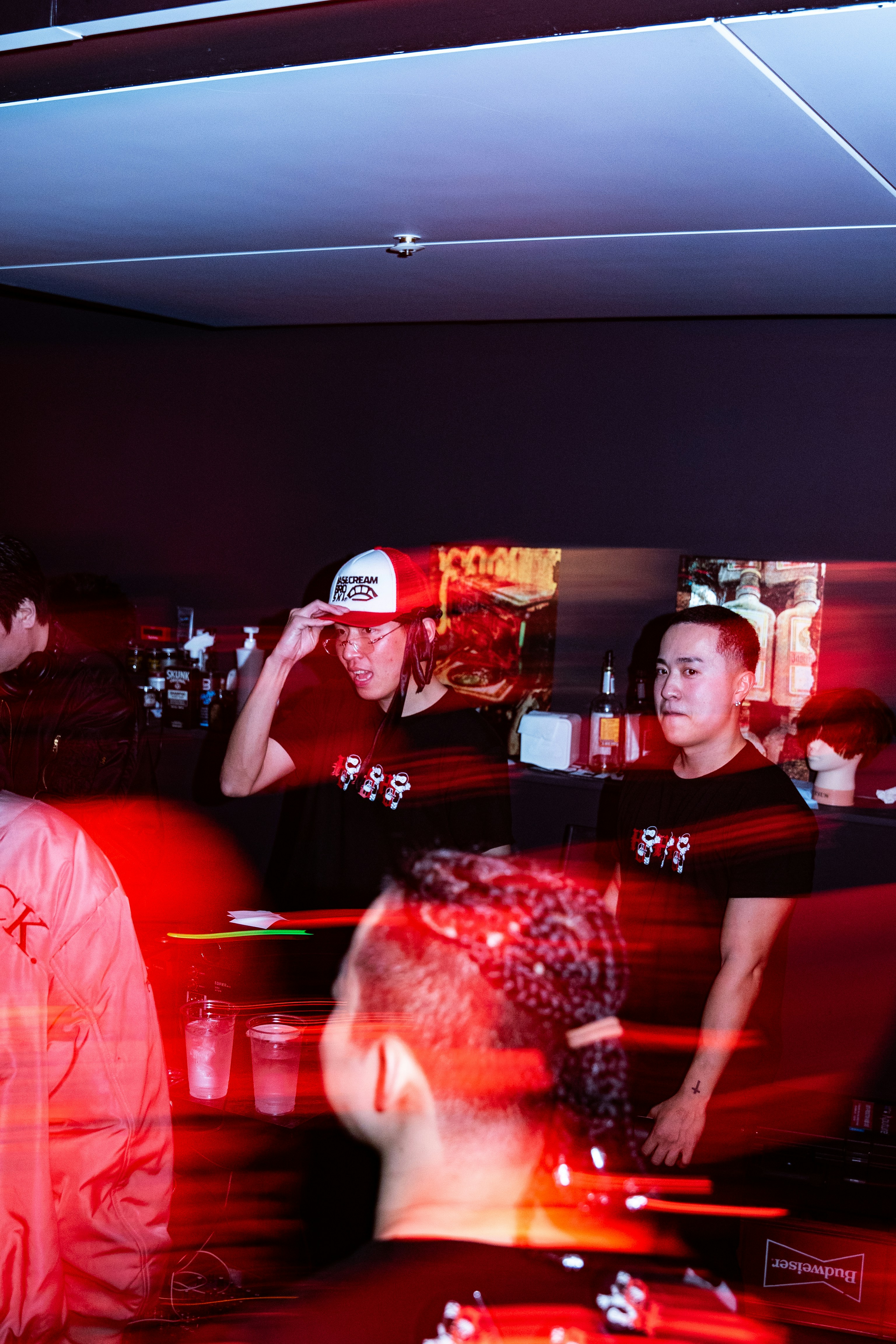 Neon Night in the Club: Red Light Trails and Faces in Motion
