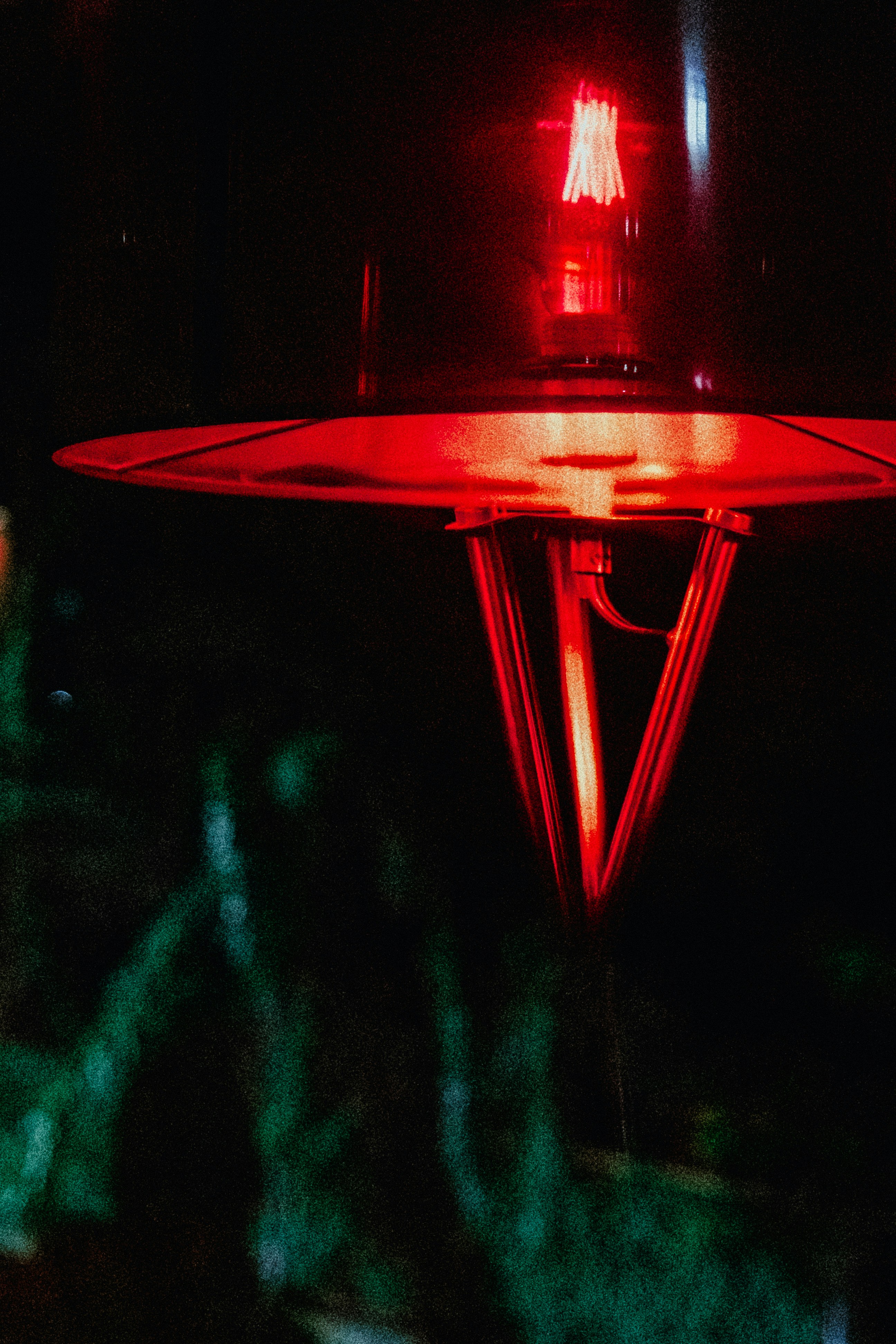 Red Beacon in the Night: A Glowing Lamp Suspended in Darkness