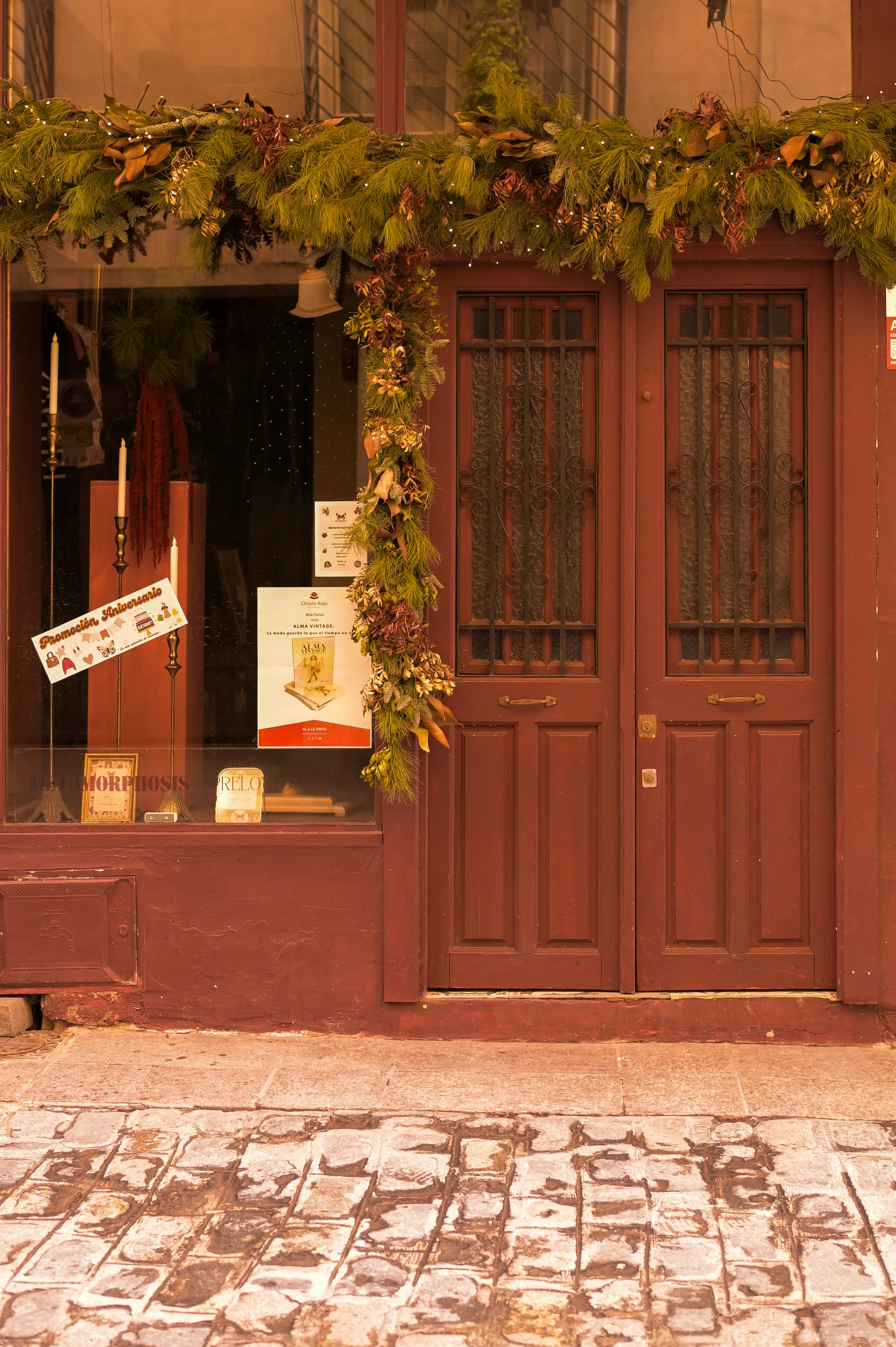 Vintage storefront doorway framed by festive greenery