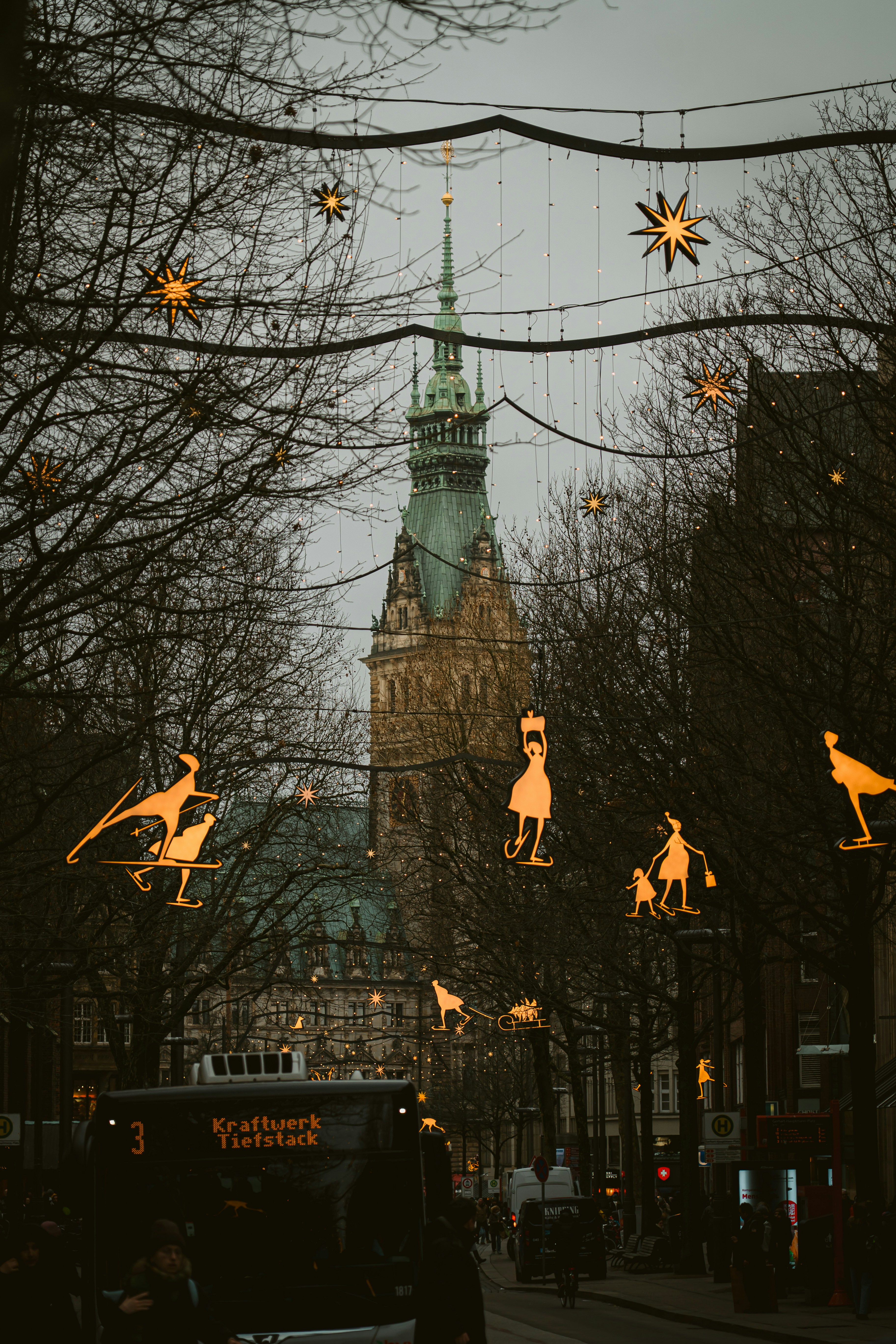 Golden silhouettes above winter streets: festive light installations frame a distant spire