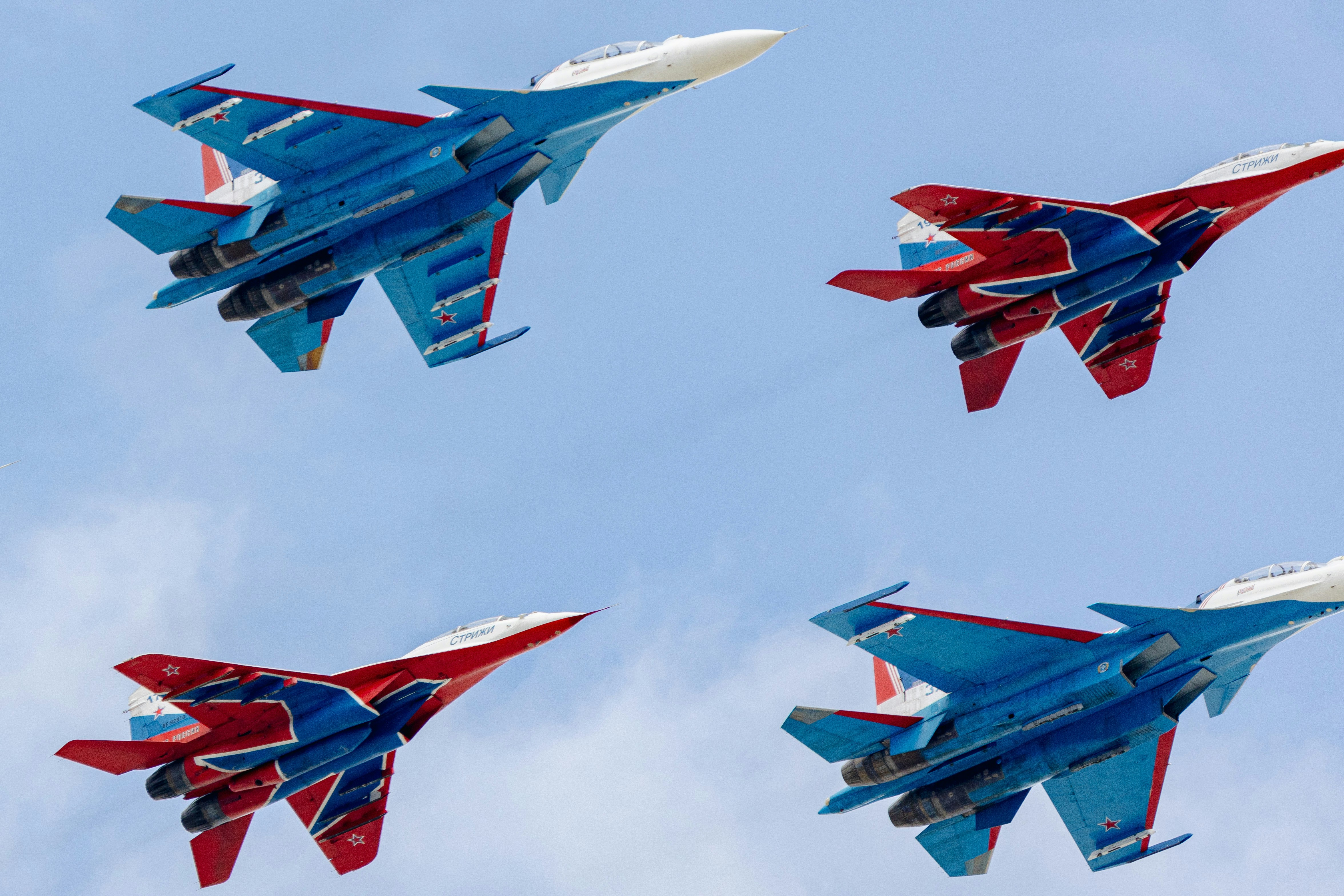 A quartet of color-sharp jets carving through a pale sky