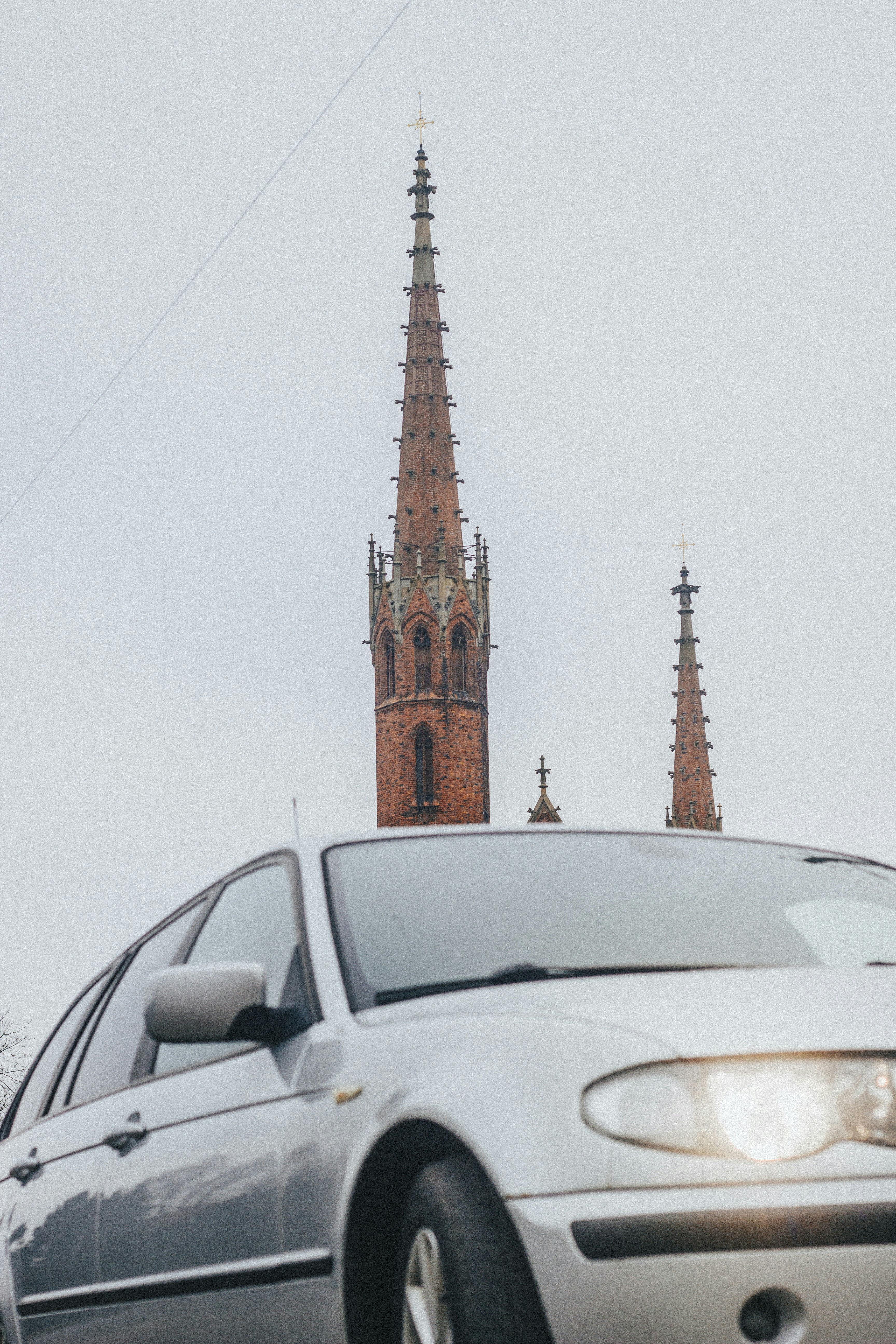 Rising Spires Behind a Parked Silver Car
