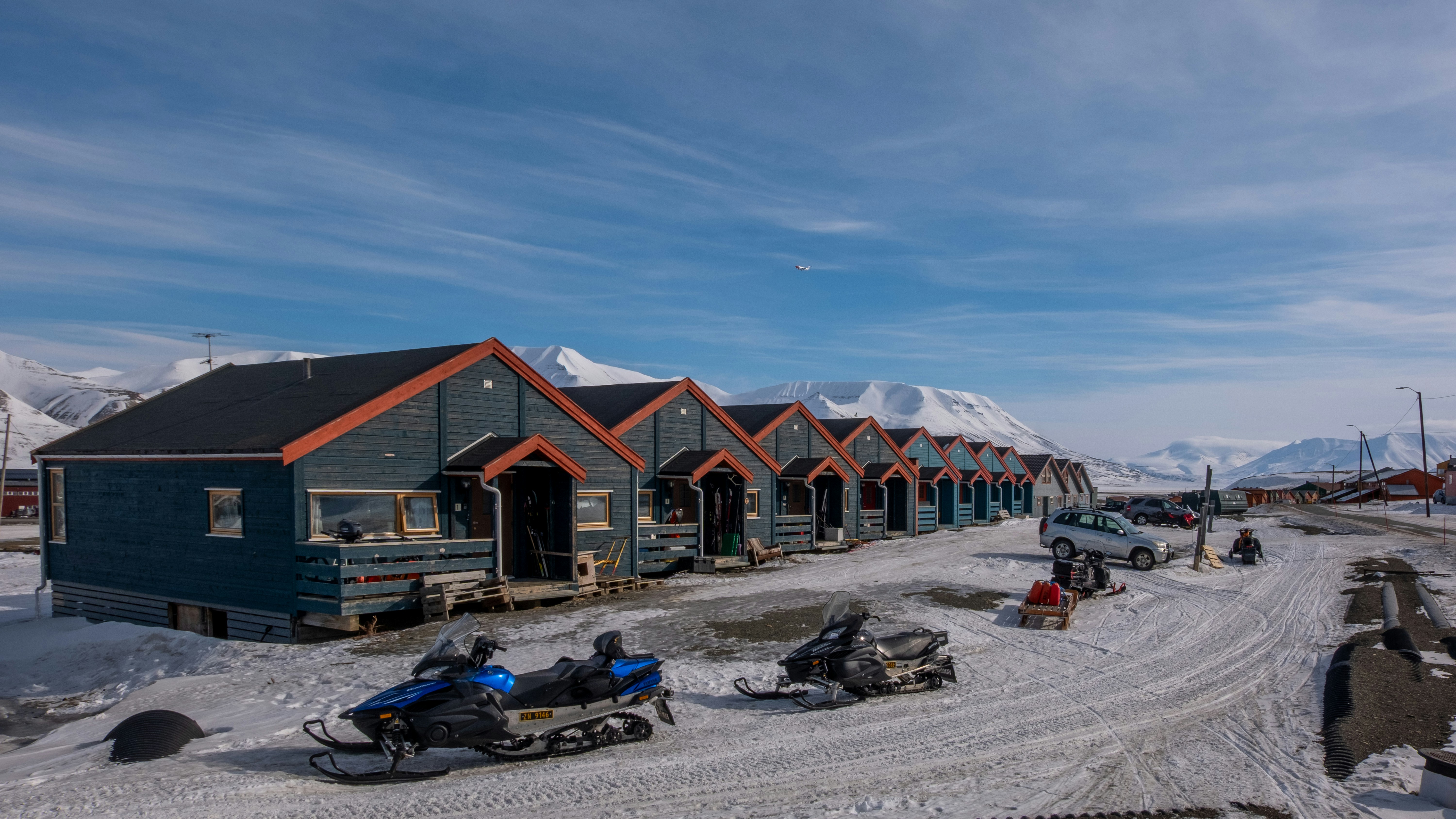 Snowbound Row: A Quiet Village of Blue Cabin Cabins under a Clear Arctic Sky