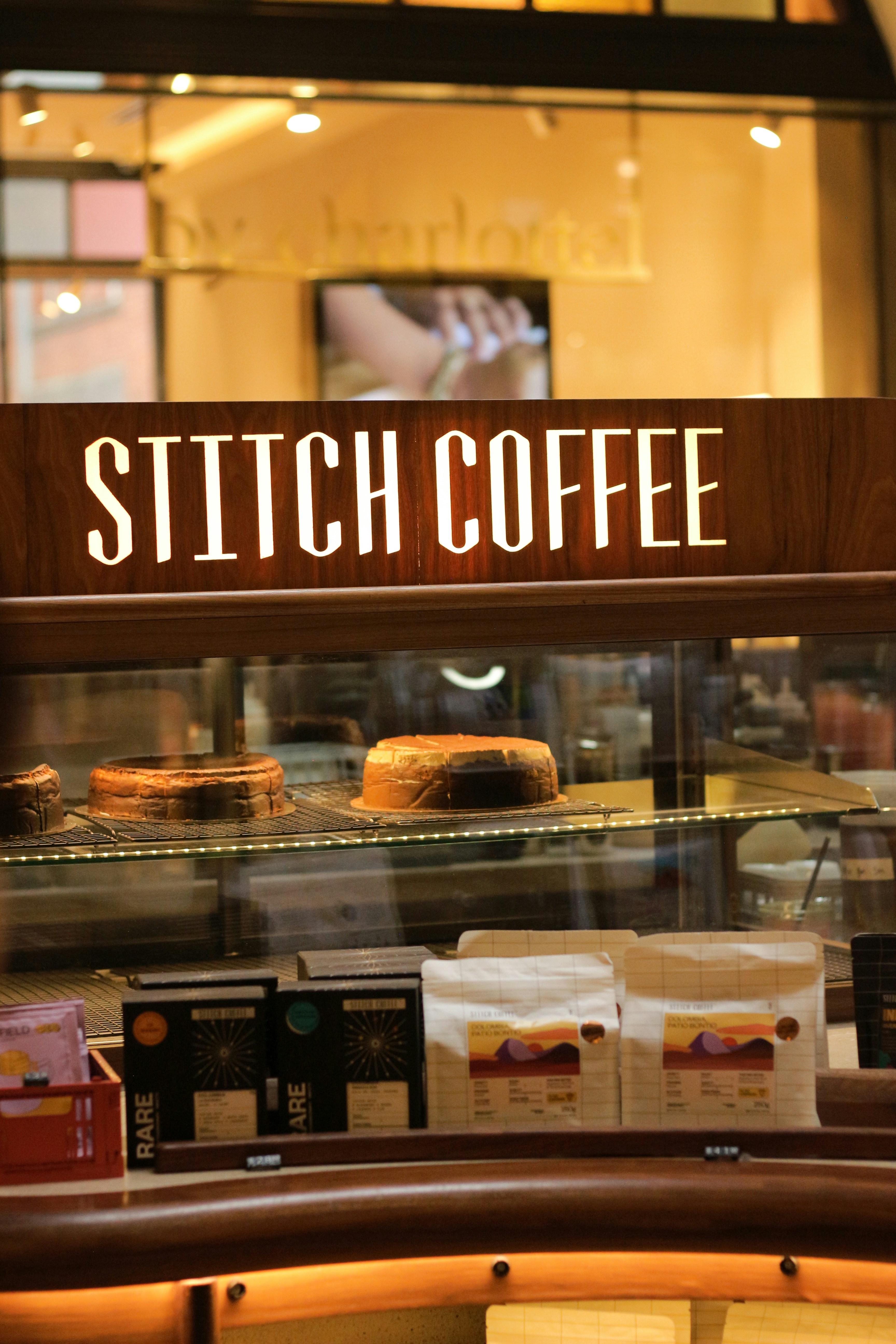 Stitch Coffee Display: Pastry Counter Through a Warm Glass