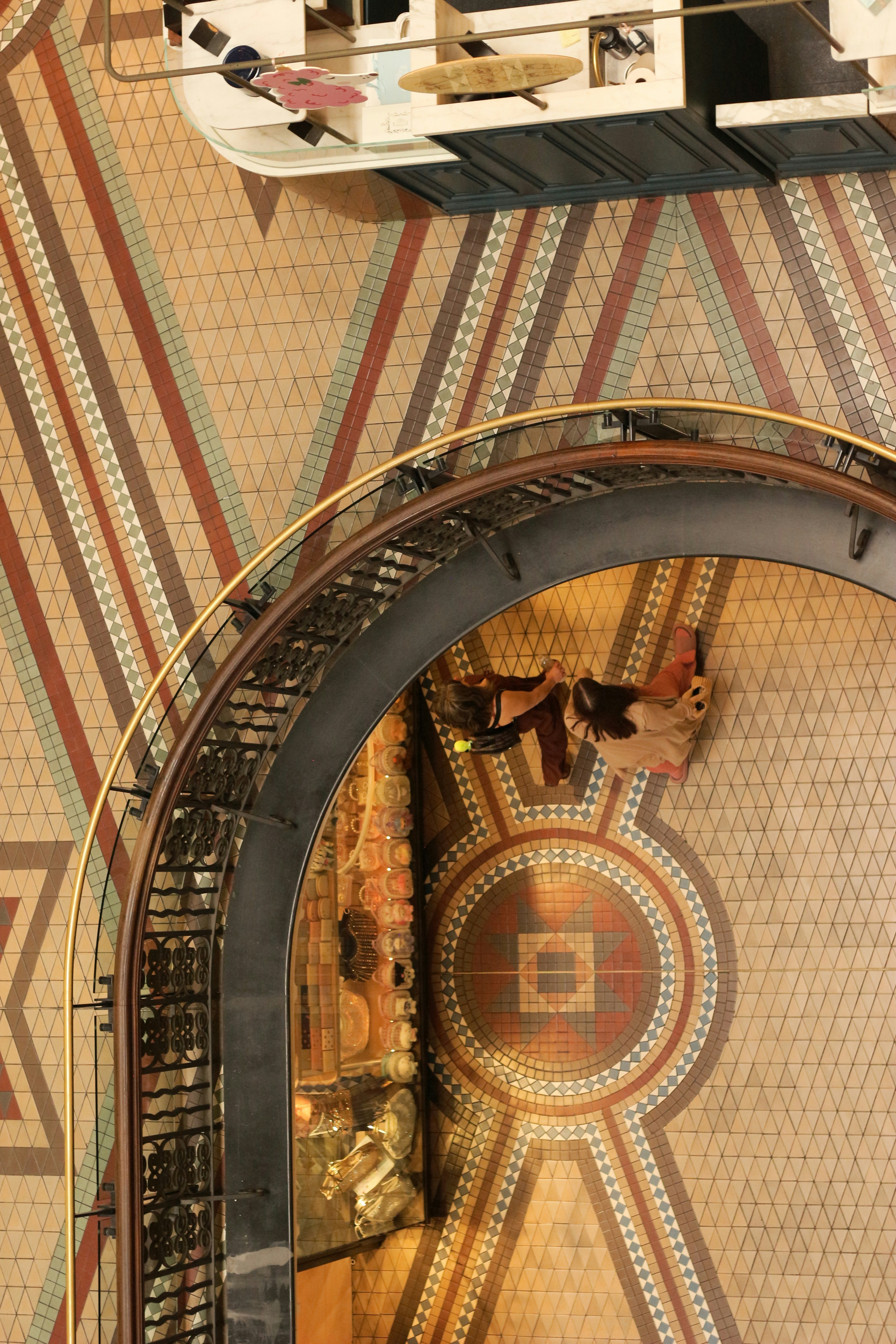 Spiral Court Archway: A Circular Mosaic Framed by Balcony Rail