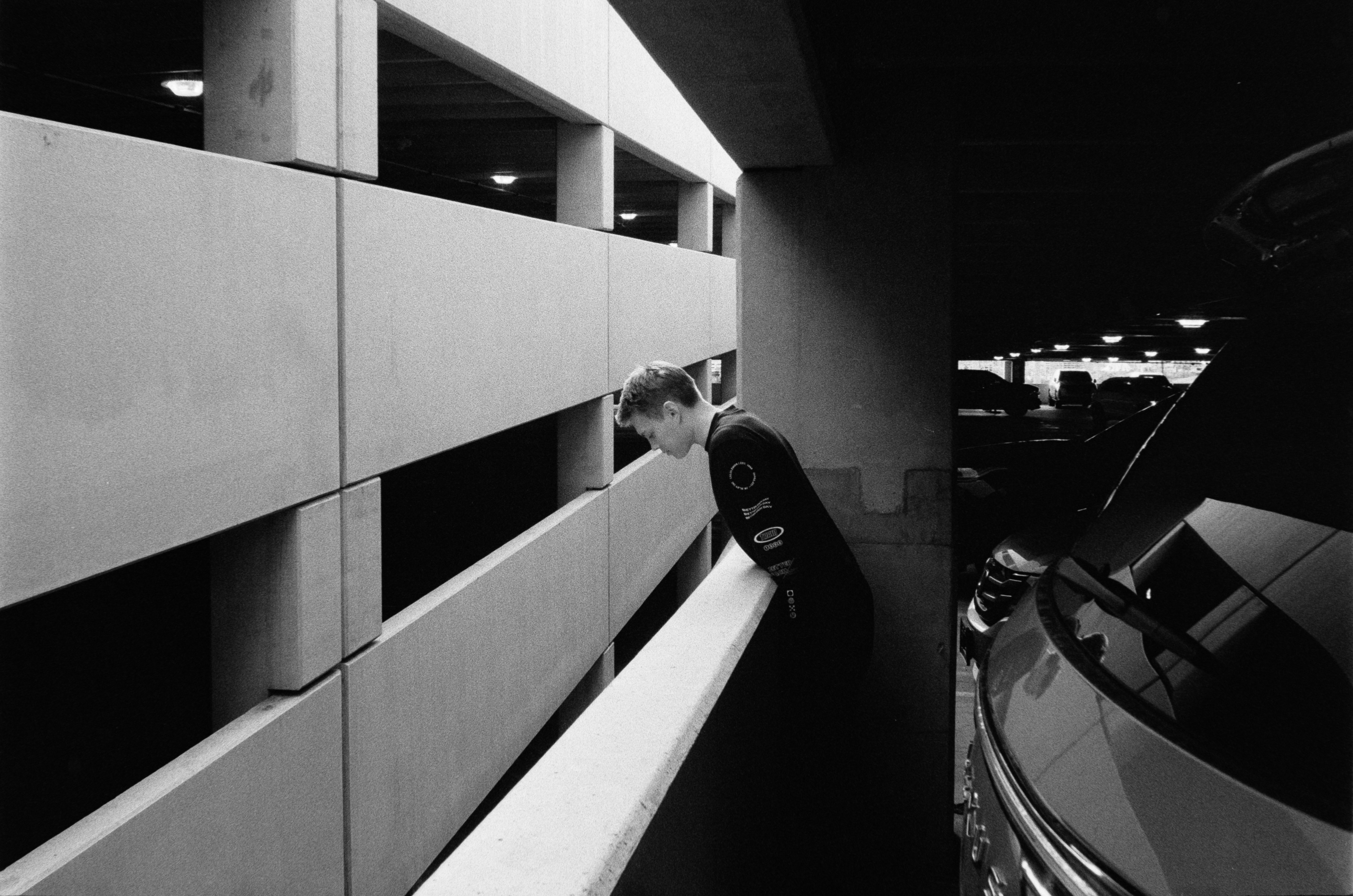 Lean Against the Edge: A Monochrome Moment in a Concrete Parking