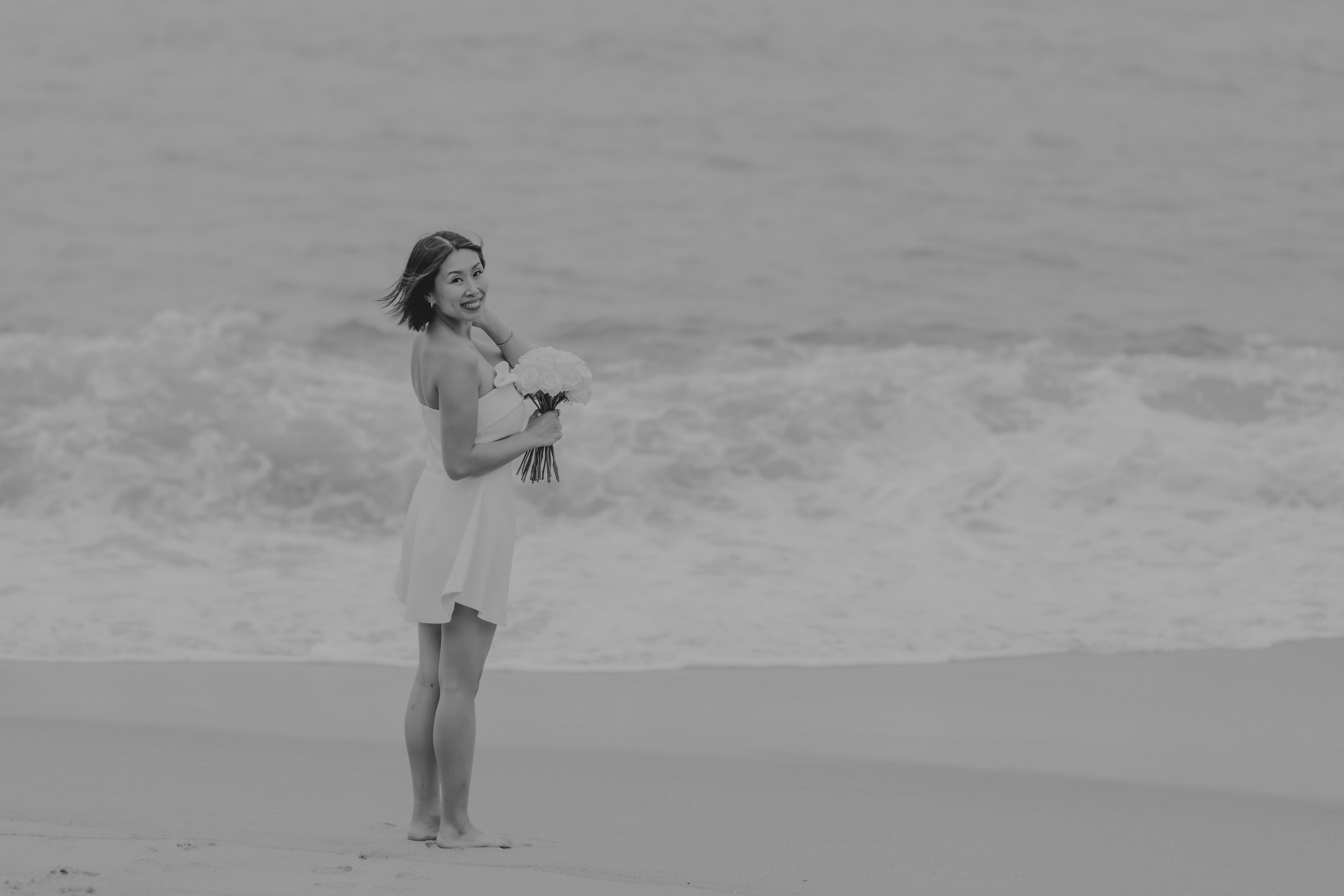 Bride on the Shore: A Quiet Moment with Bouquet in Hand