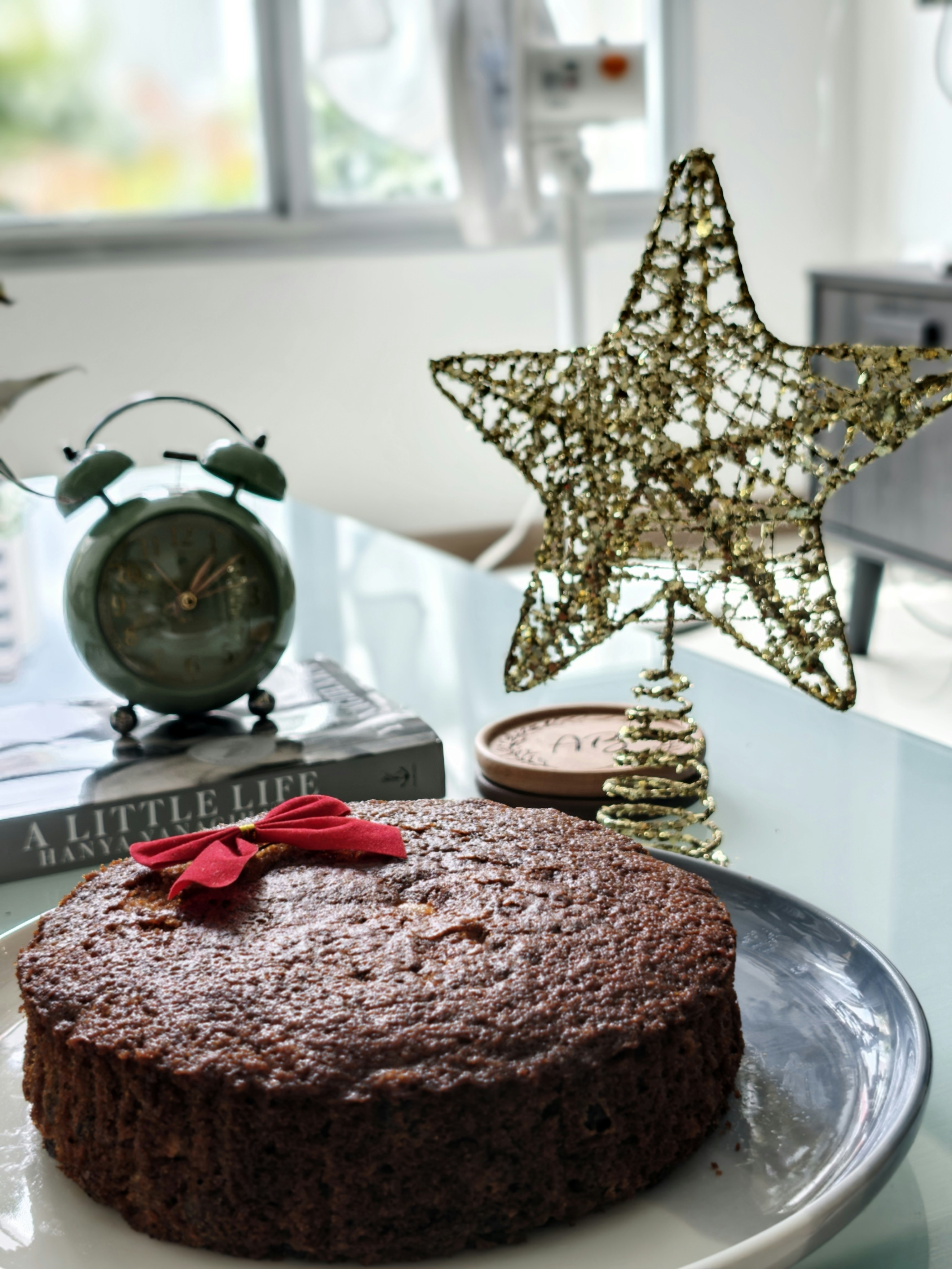 Christmas cake with festive star decoration and alarm clock.