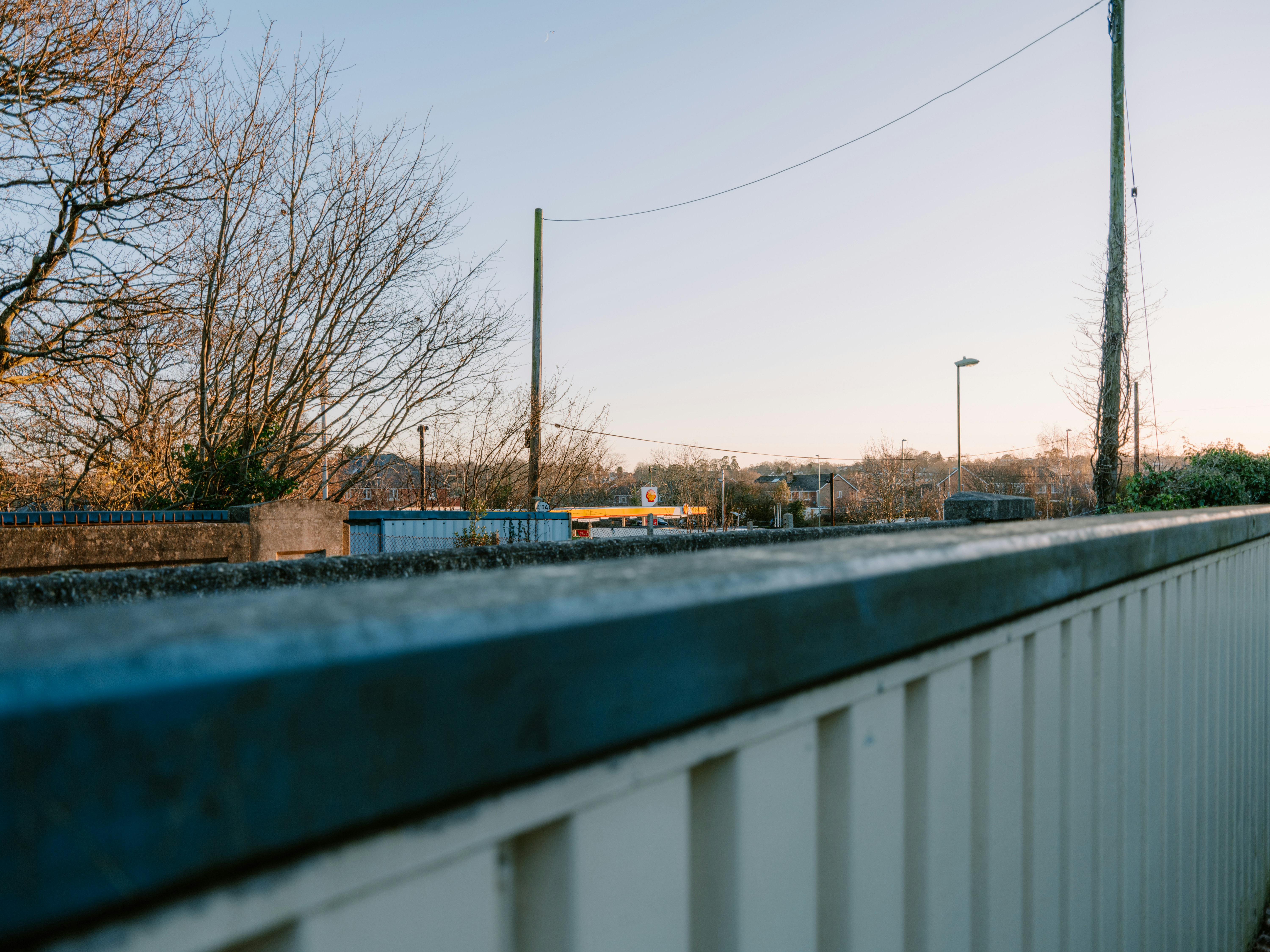 Rail-Top Quiet: Evening Light on a Quiet Street
