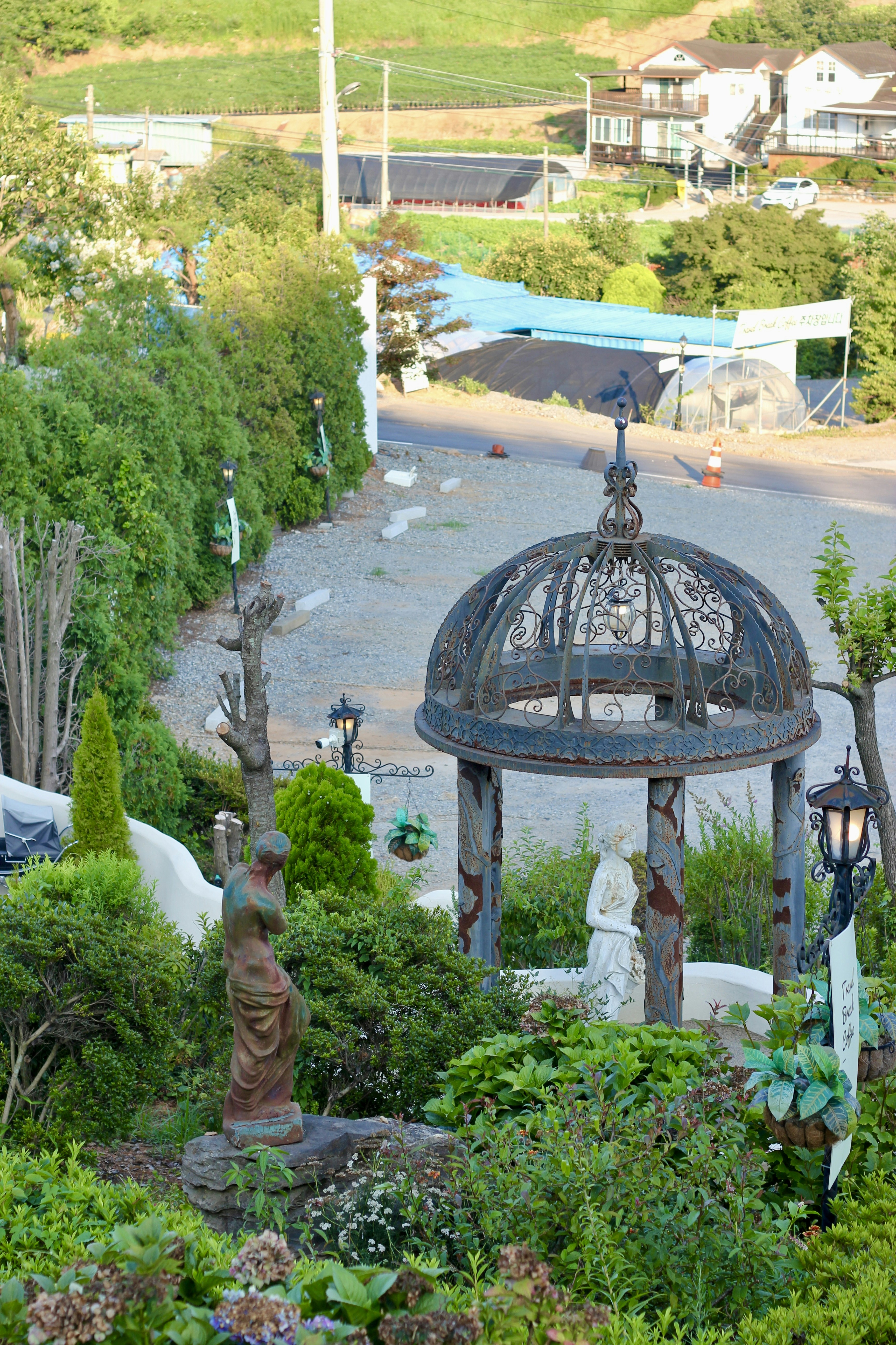 Iron Gazebo Reverie Amid Garden Statues