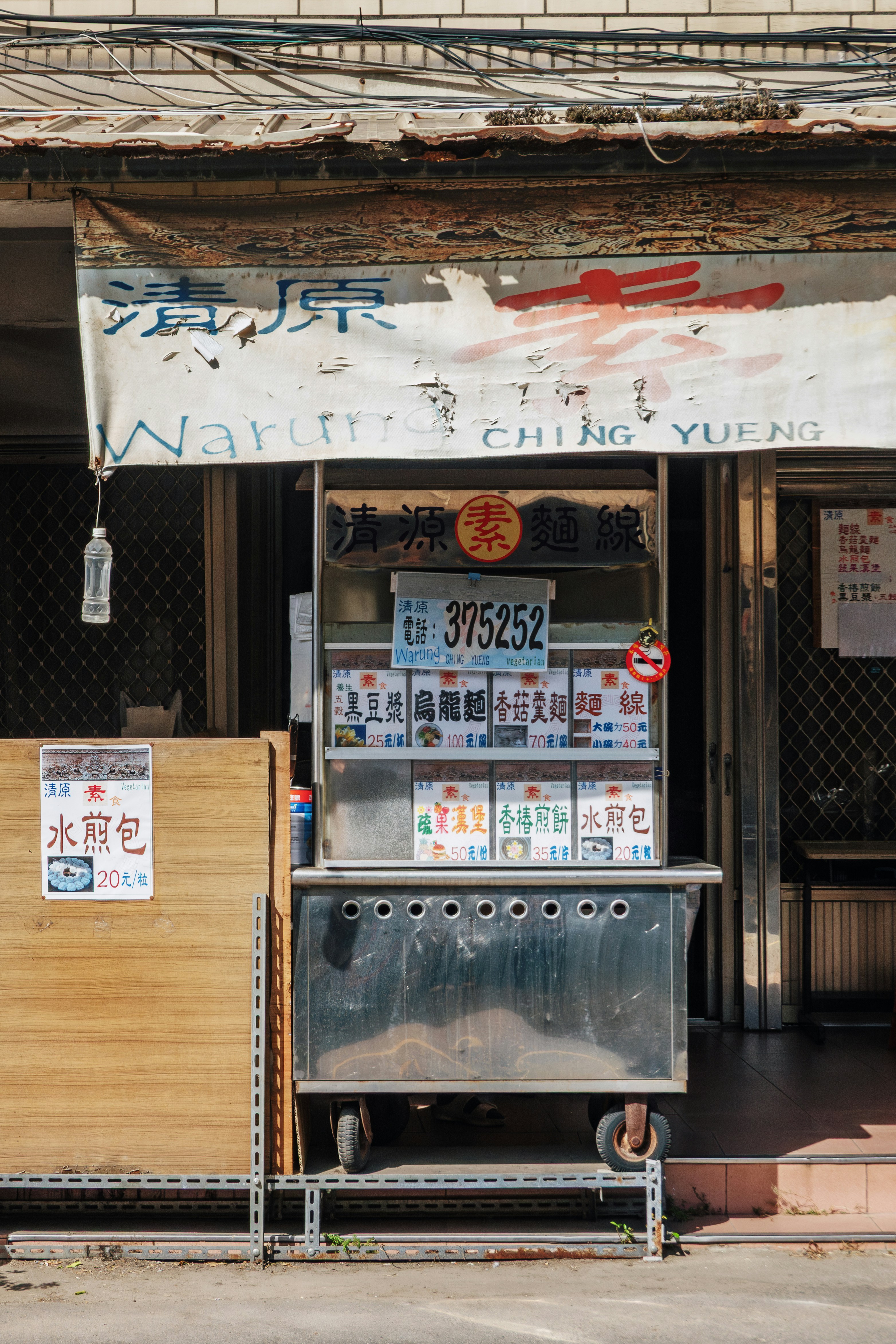 Steam-kissed storefront: a noodle stand under weathered awning