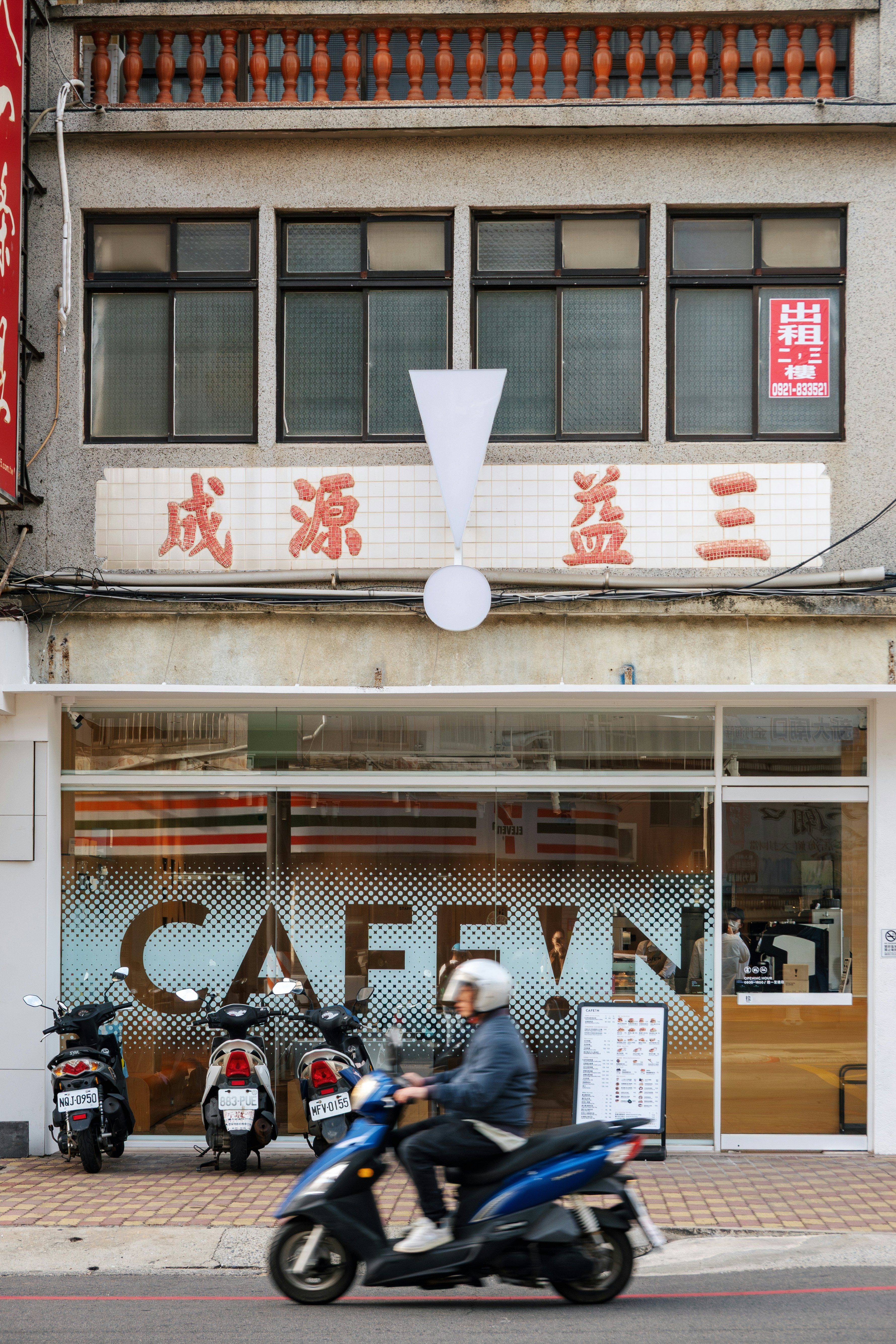 Scooter in Motion Before a Café Window Display