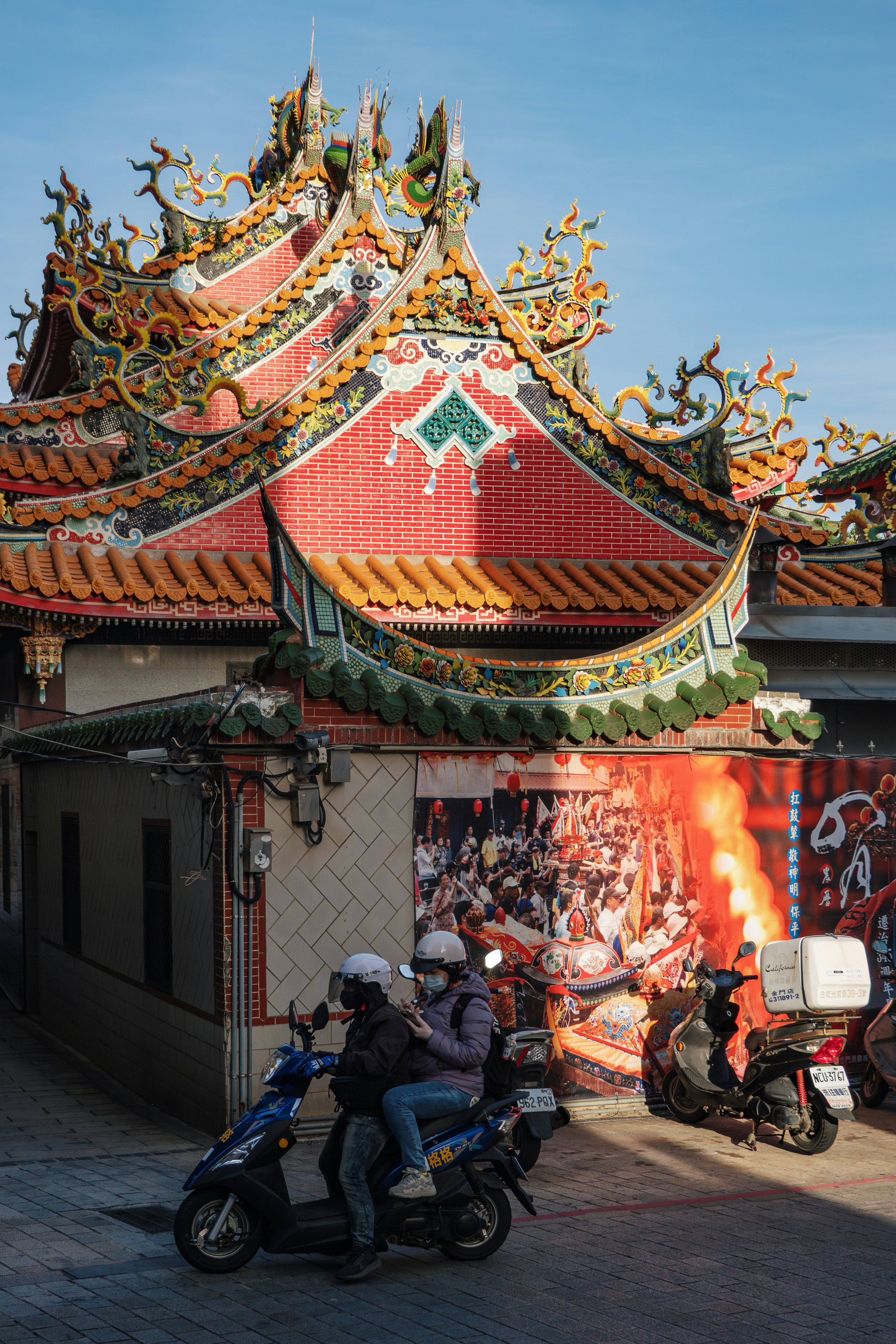 Temple Facade Under Neon Tapestry: Motorcycles at the Threshold