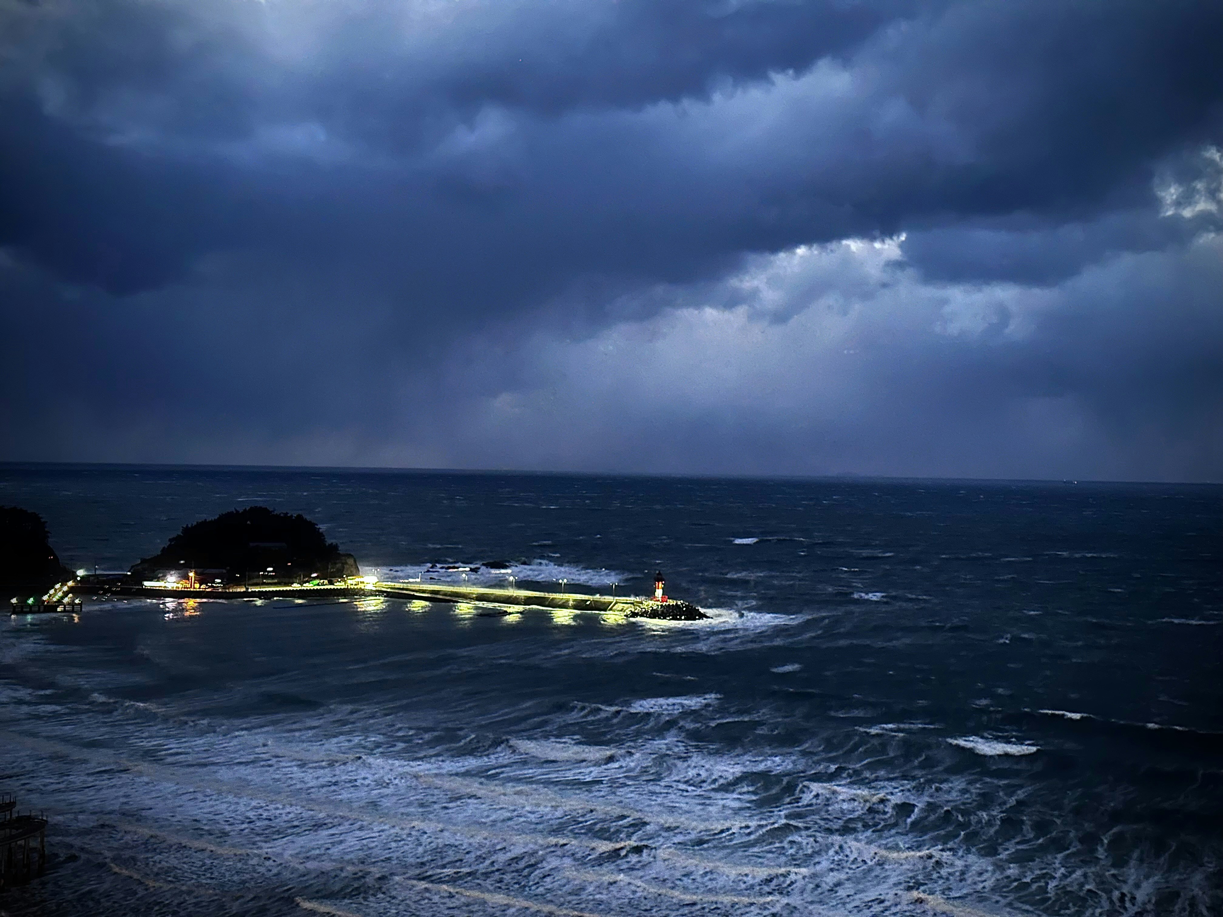 Lighthouse Line: A Sea Road Beneath Stormy Skies