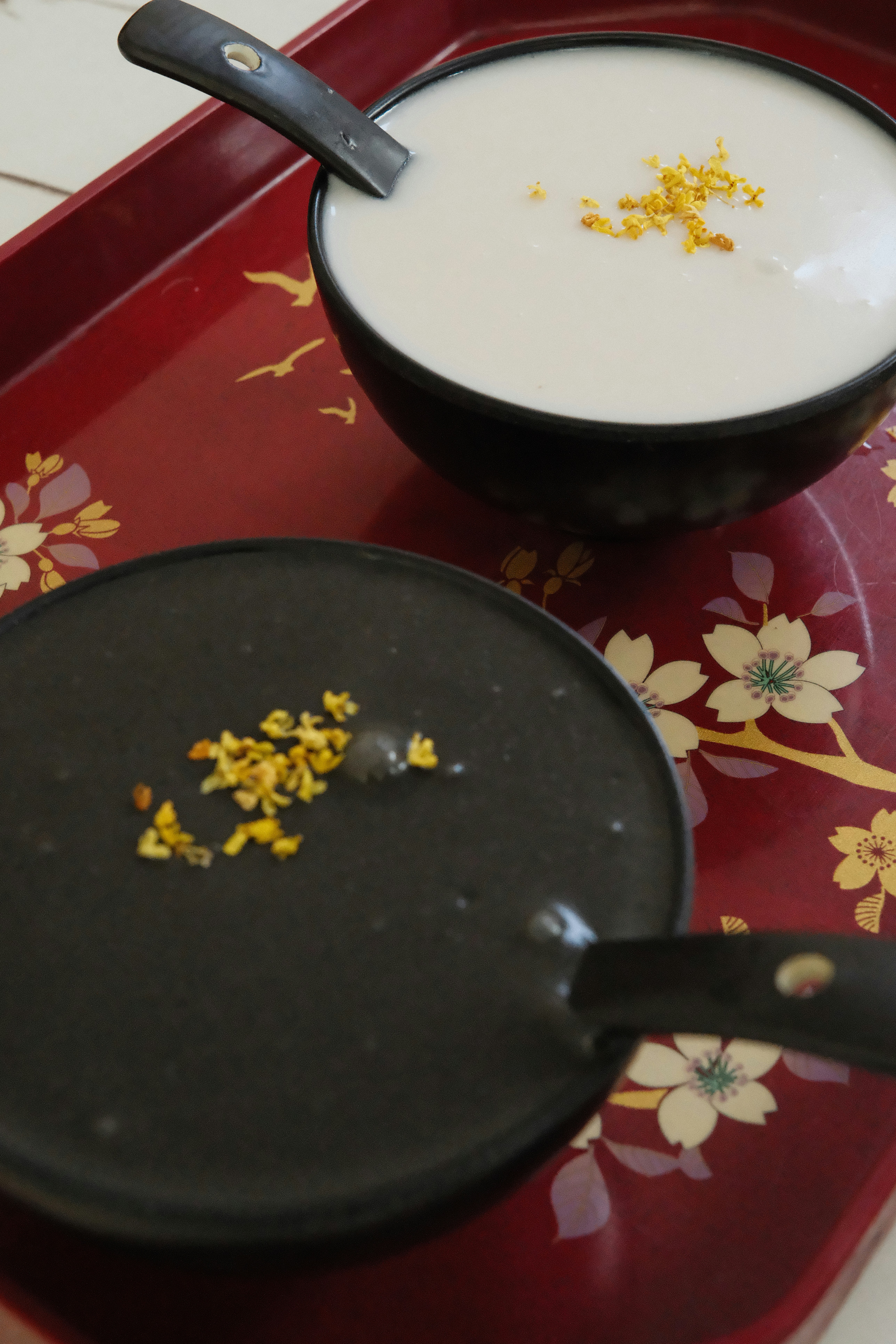 Two bowls of sweet soup with osmanthus flowers.