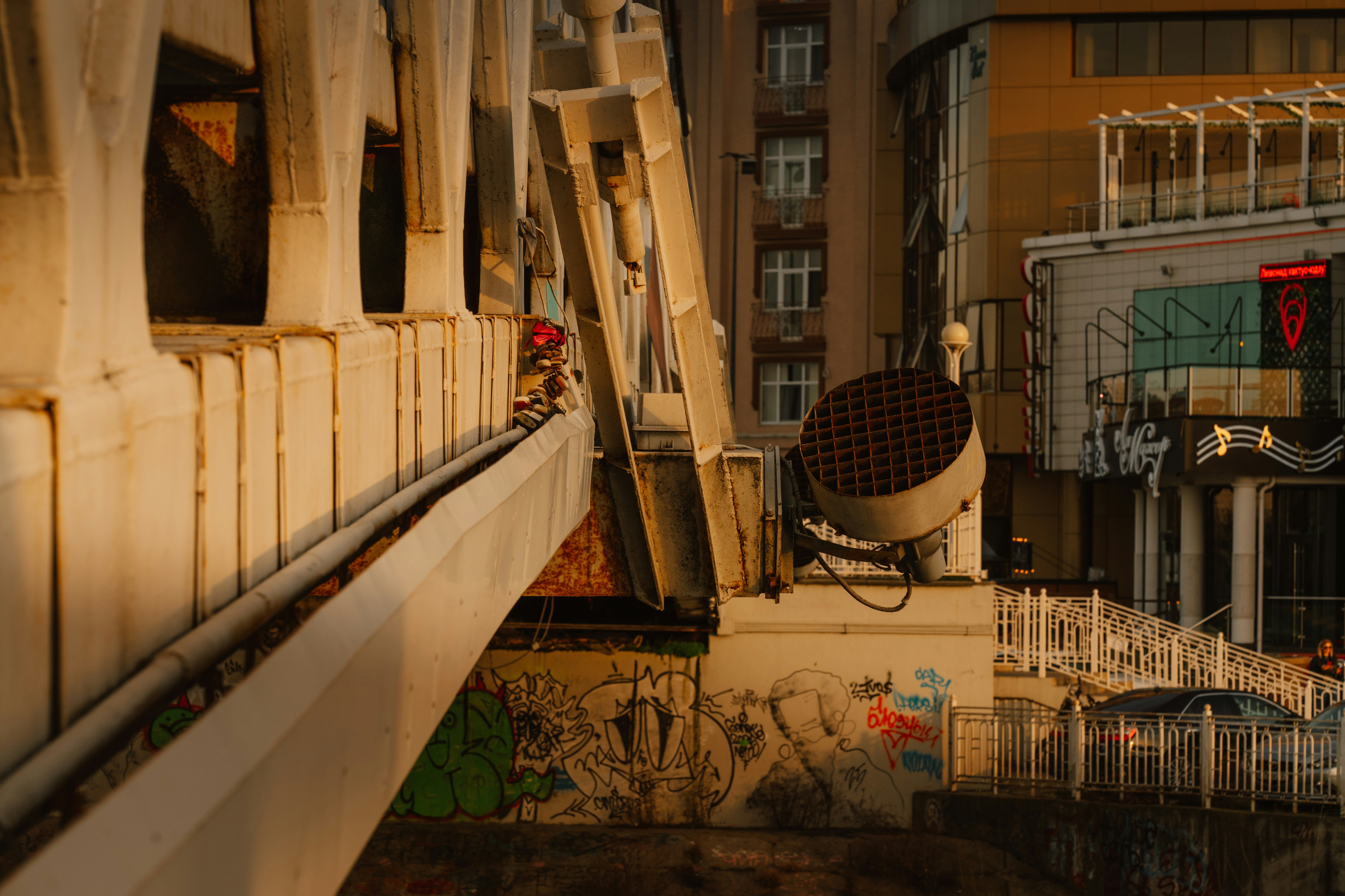Graffitied Canal Underpass Framed by Industrial Bridge