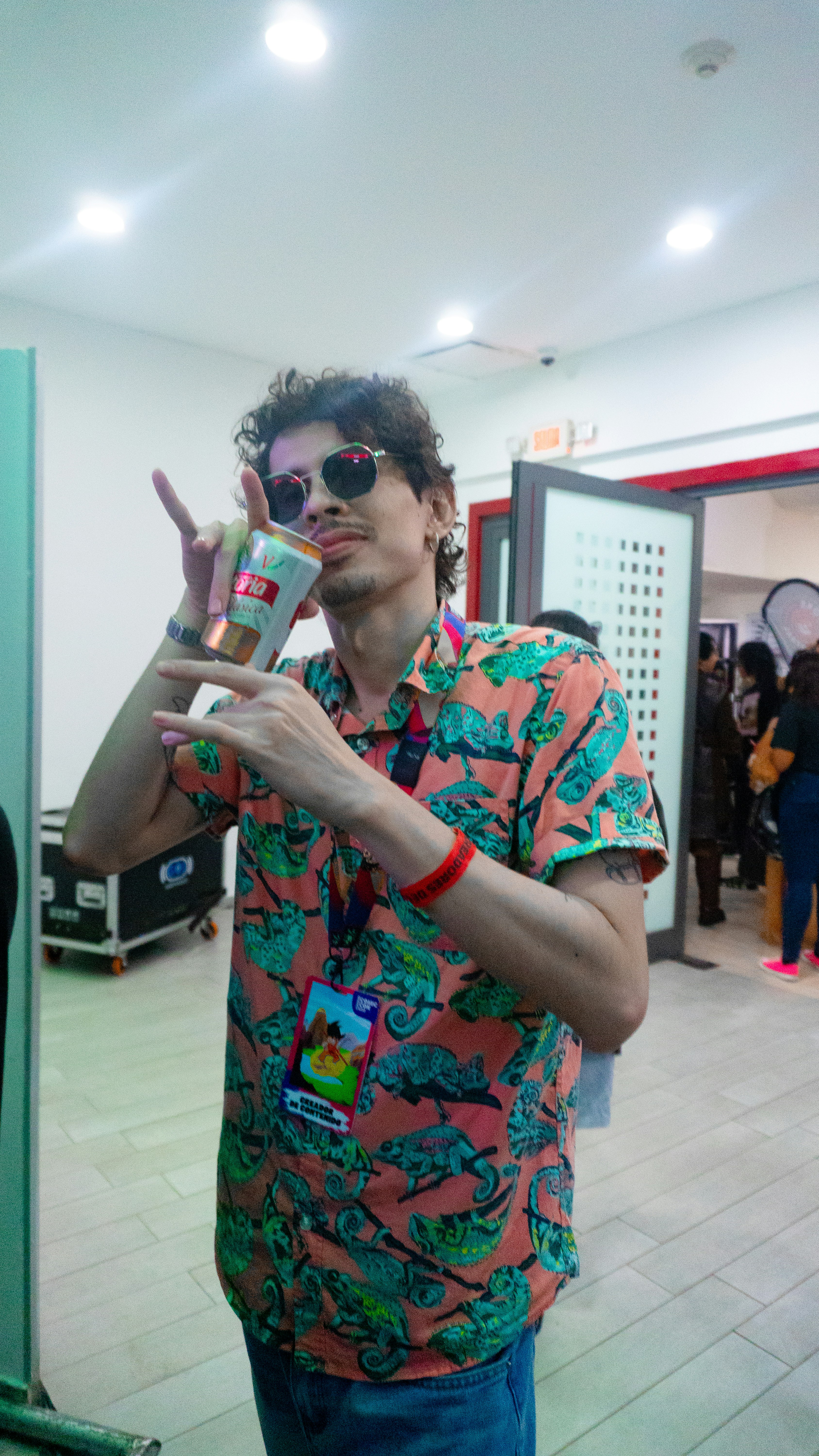 Neon-lit Party Pose: A Sunglassed Reveler Cheers with a Drink