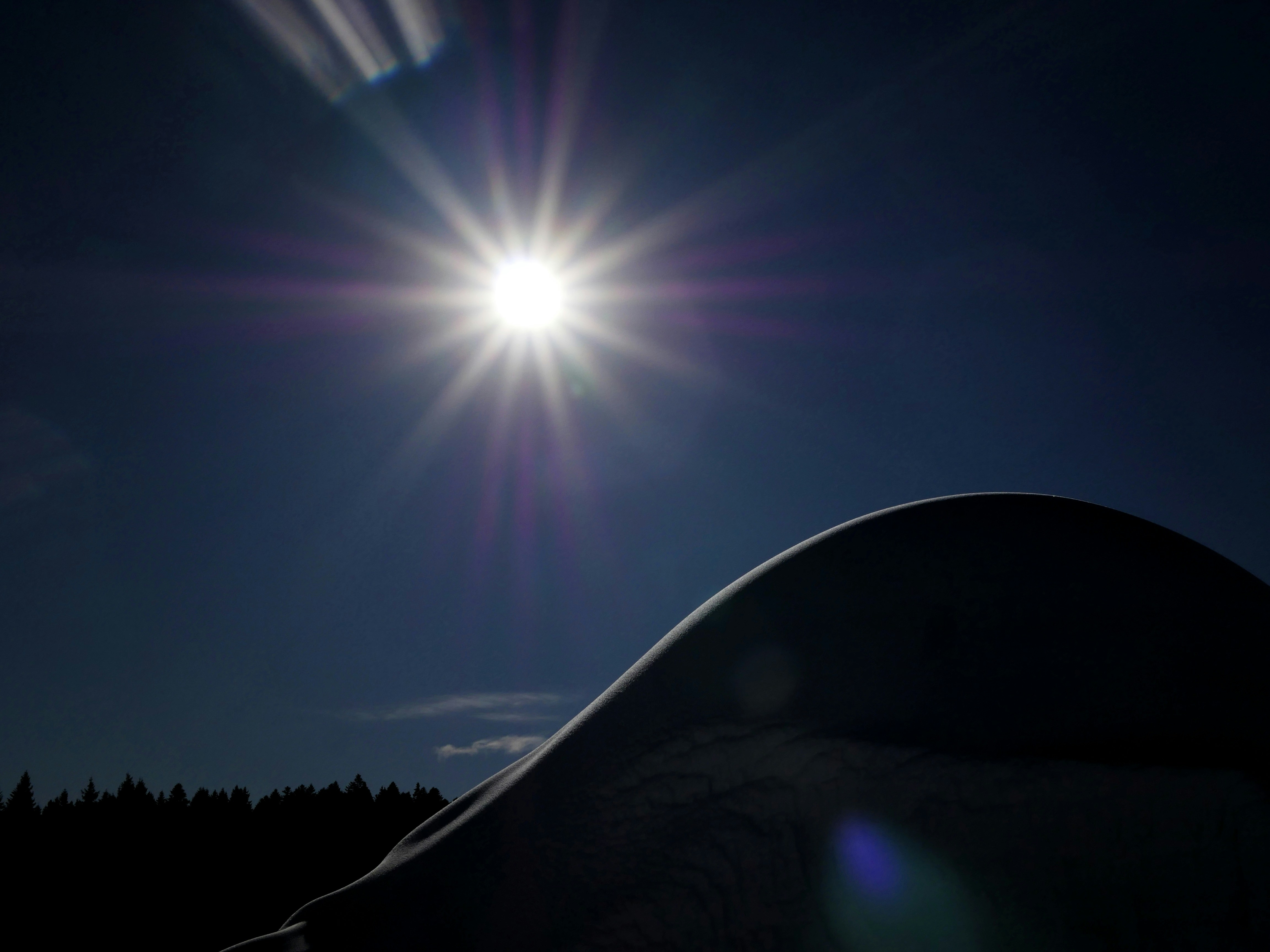 Sunlit Contour: A Snow-Capped Crest Under a Crisp Sky