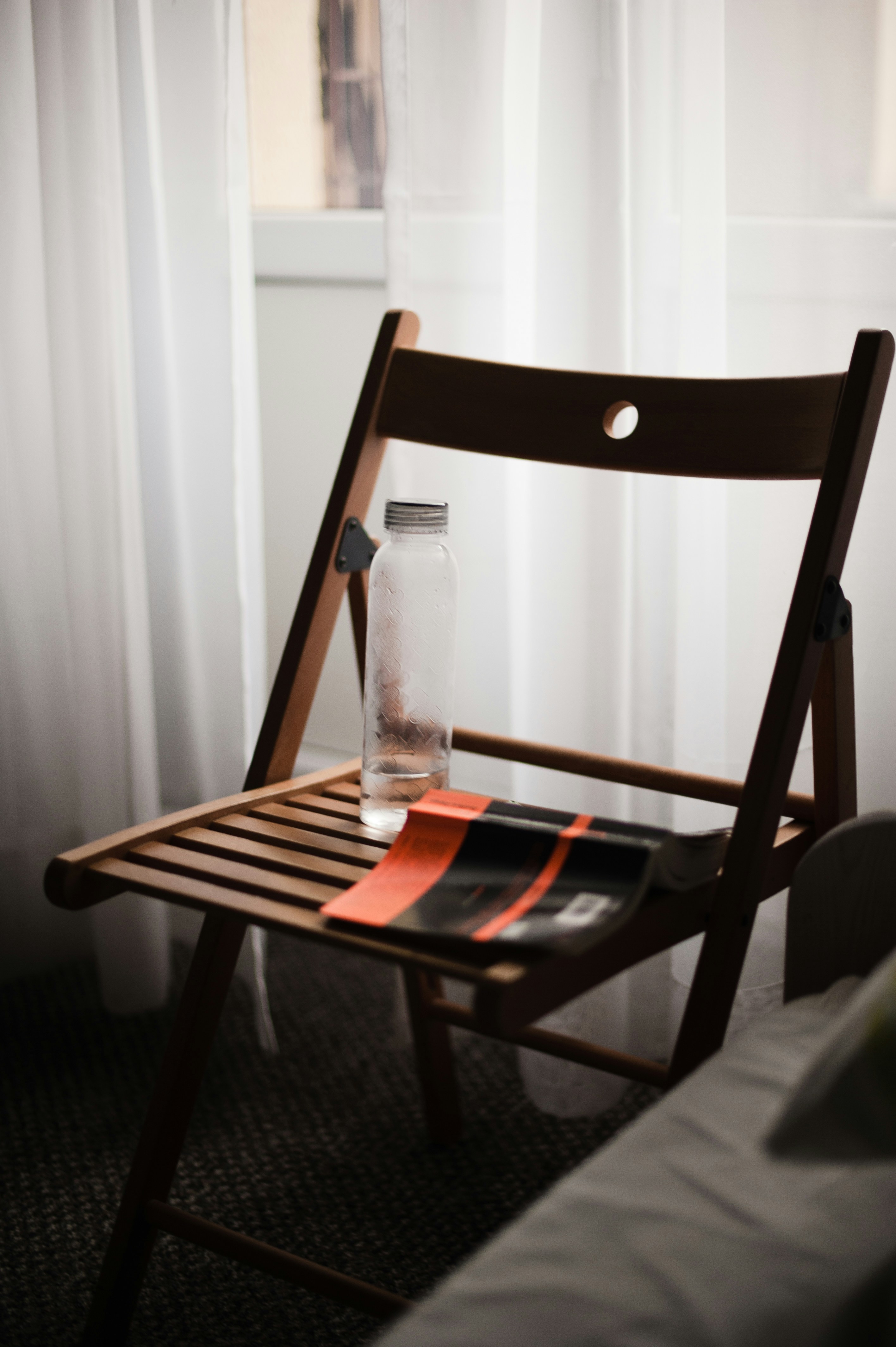 Still Life on a Quiet Morning: A Glass Bottle and Magazine on a Wooden Chair