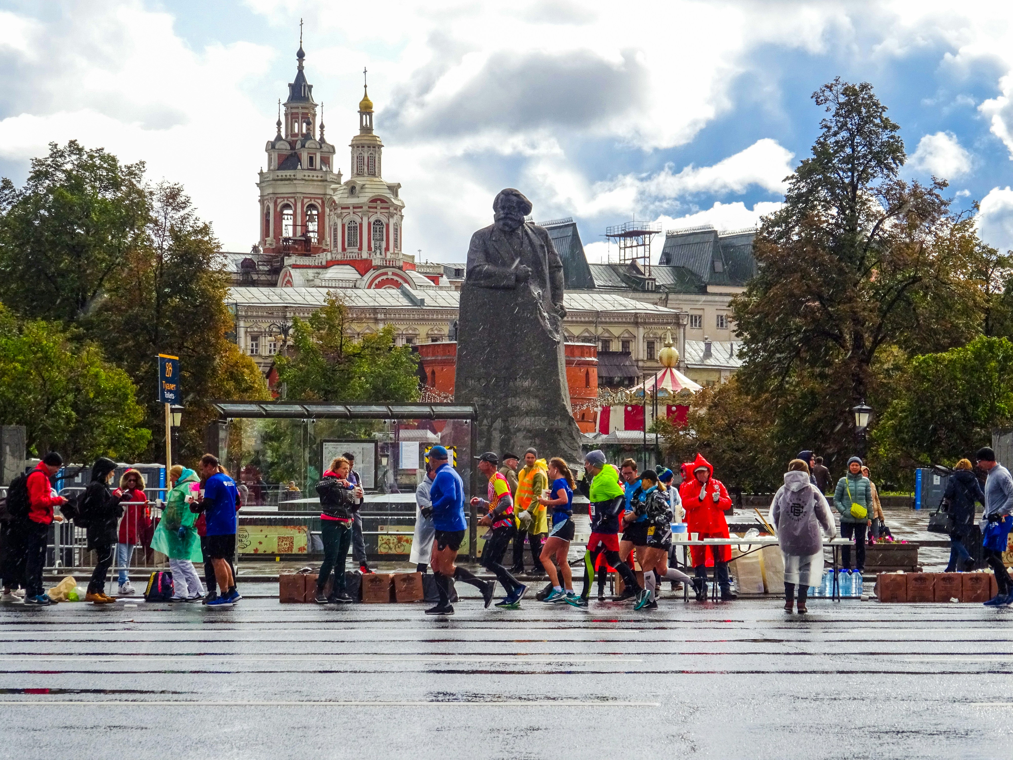 People gathered near a large statue in a city square.