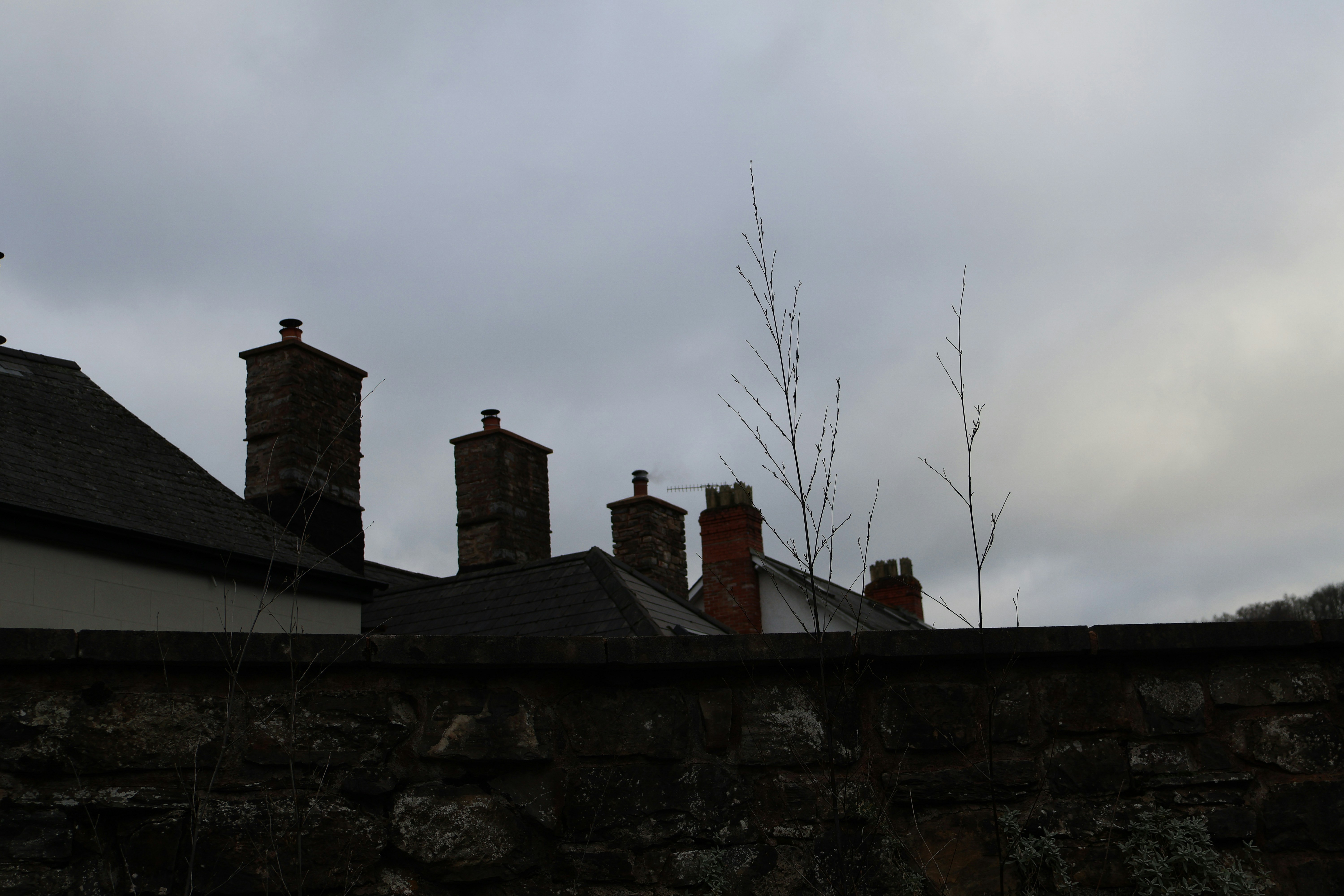 Chimney Line at Dusk: Rooftops Against a Cloudy Sky