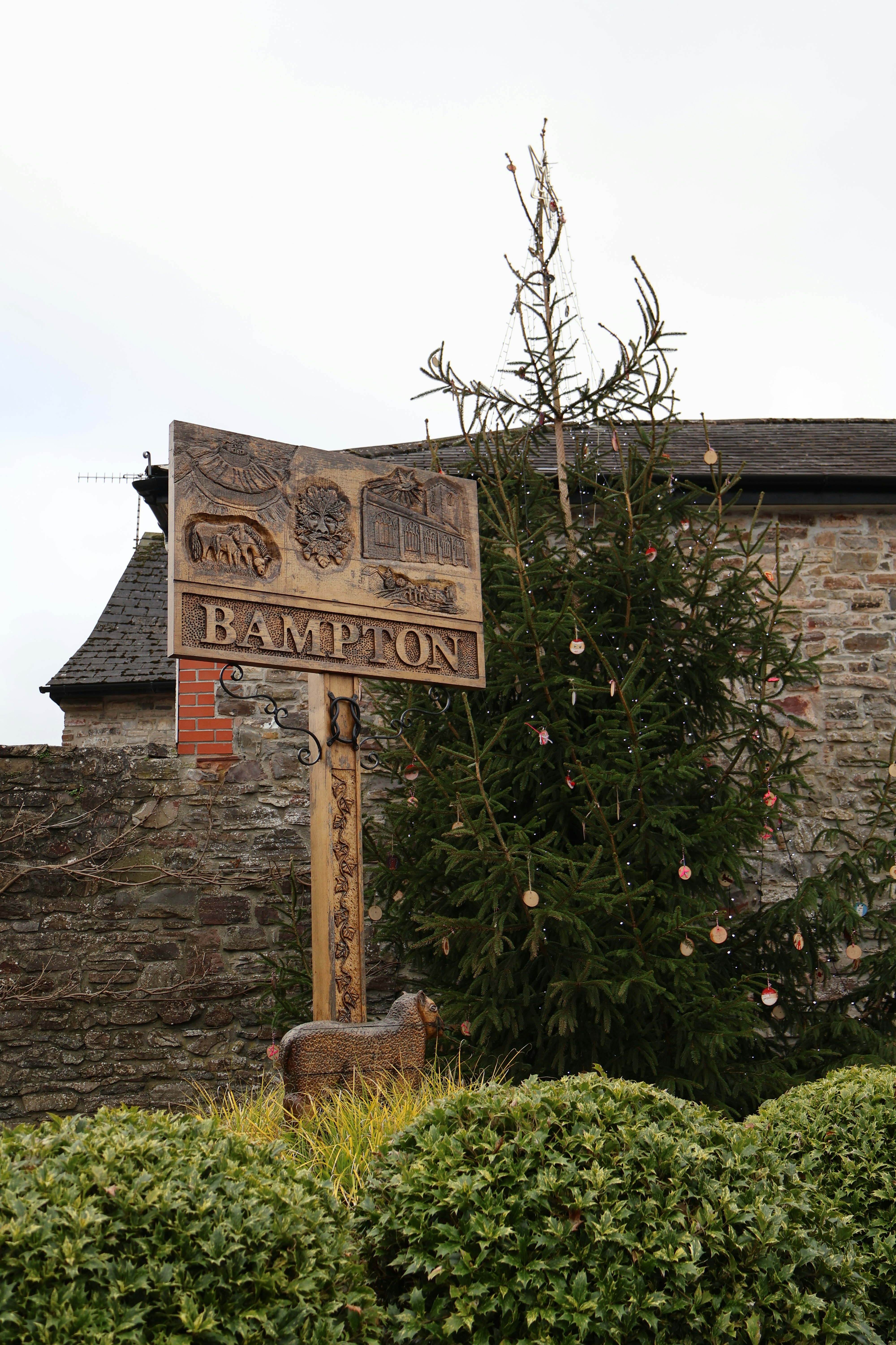 Timber Sign and Christmas Tree at a Quiet Village Corner