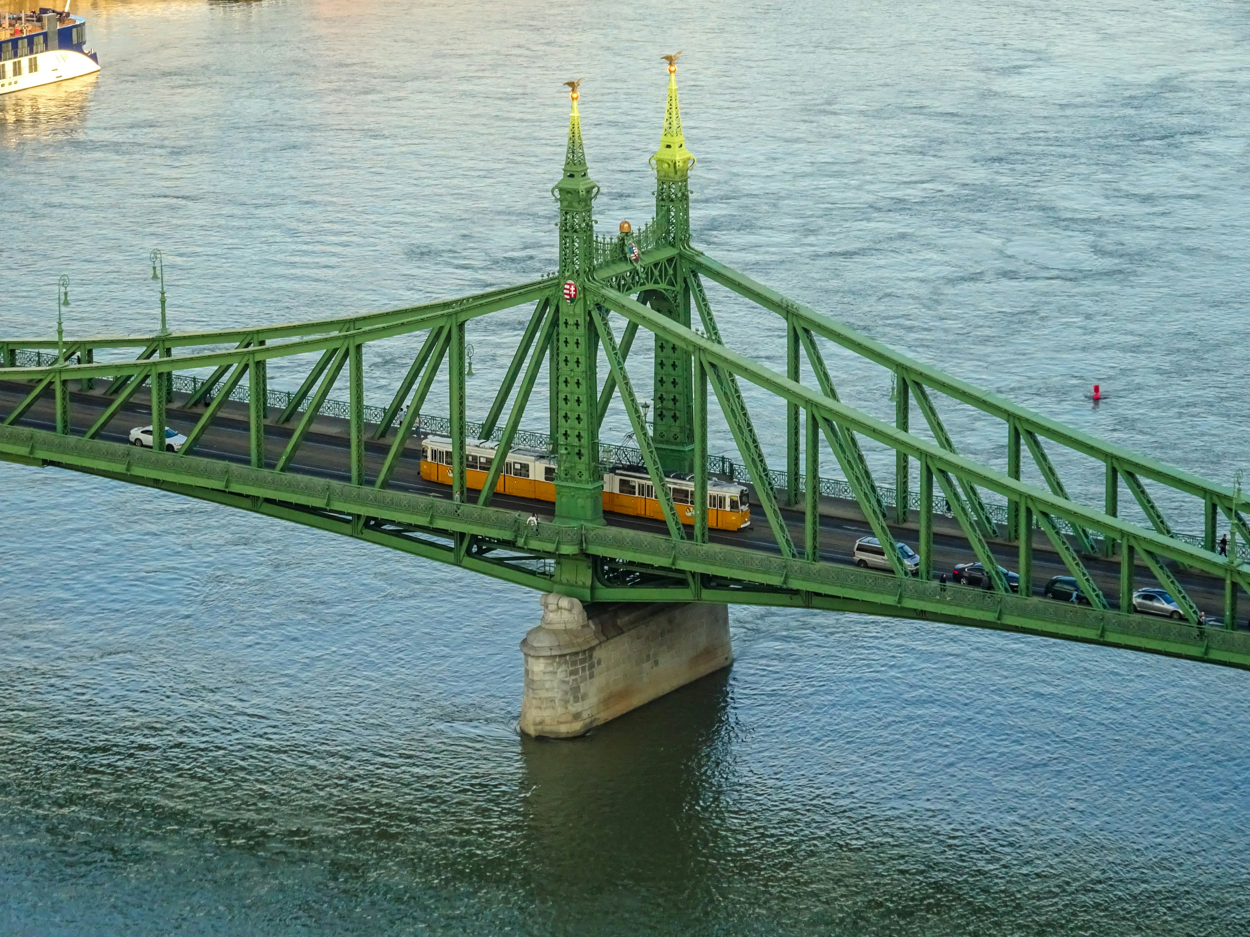 Green bridge with tram and cars crossing river photo – Free Travel ...