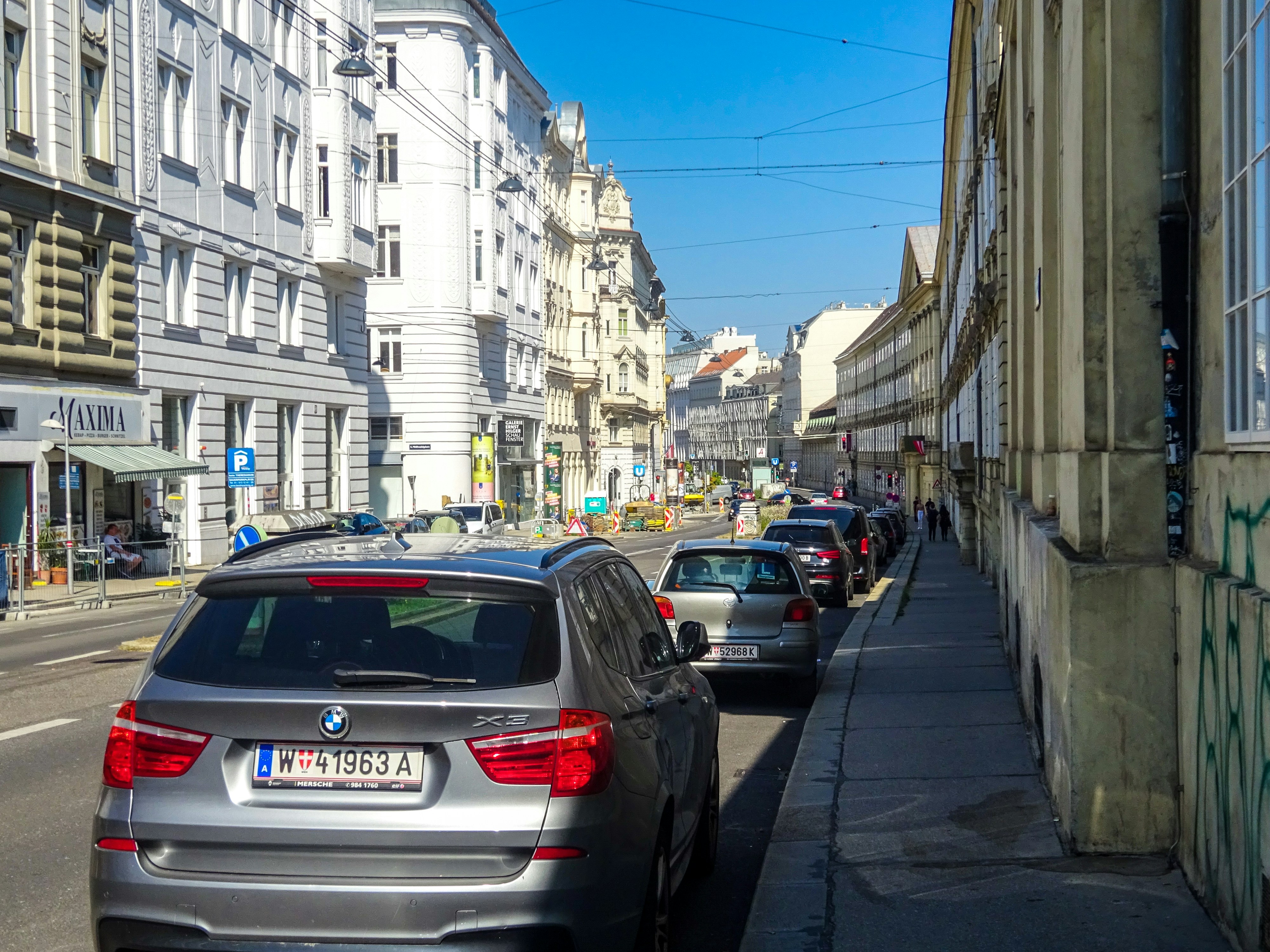 City Street Corridor: Cars in Line Under a Bright Blue Sky