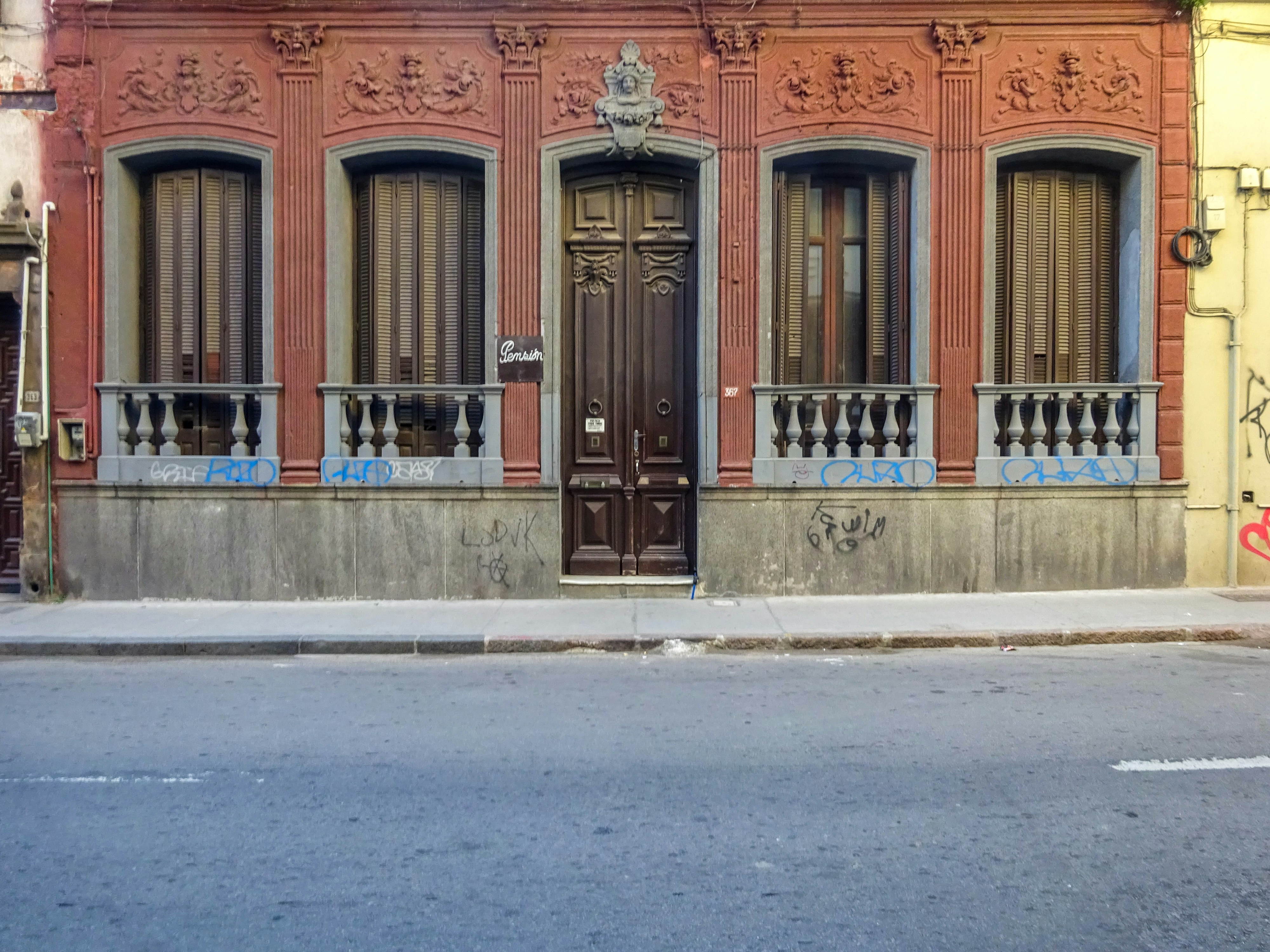 Ornate red building facade with large wooden doors. photo – Free Window Image on Unsplash