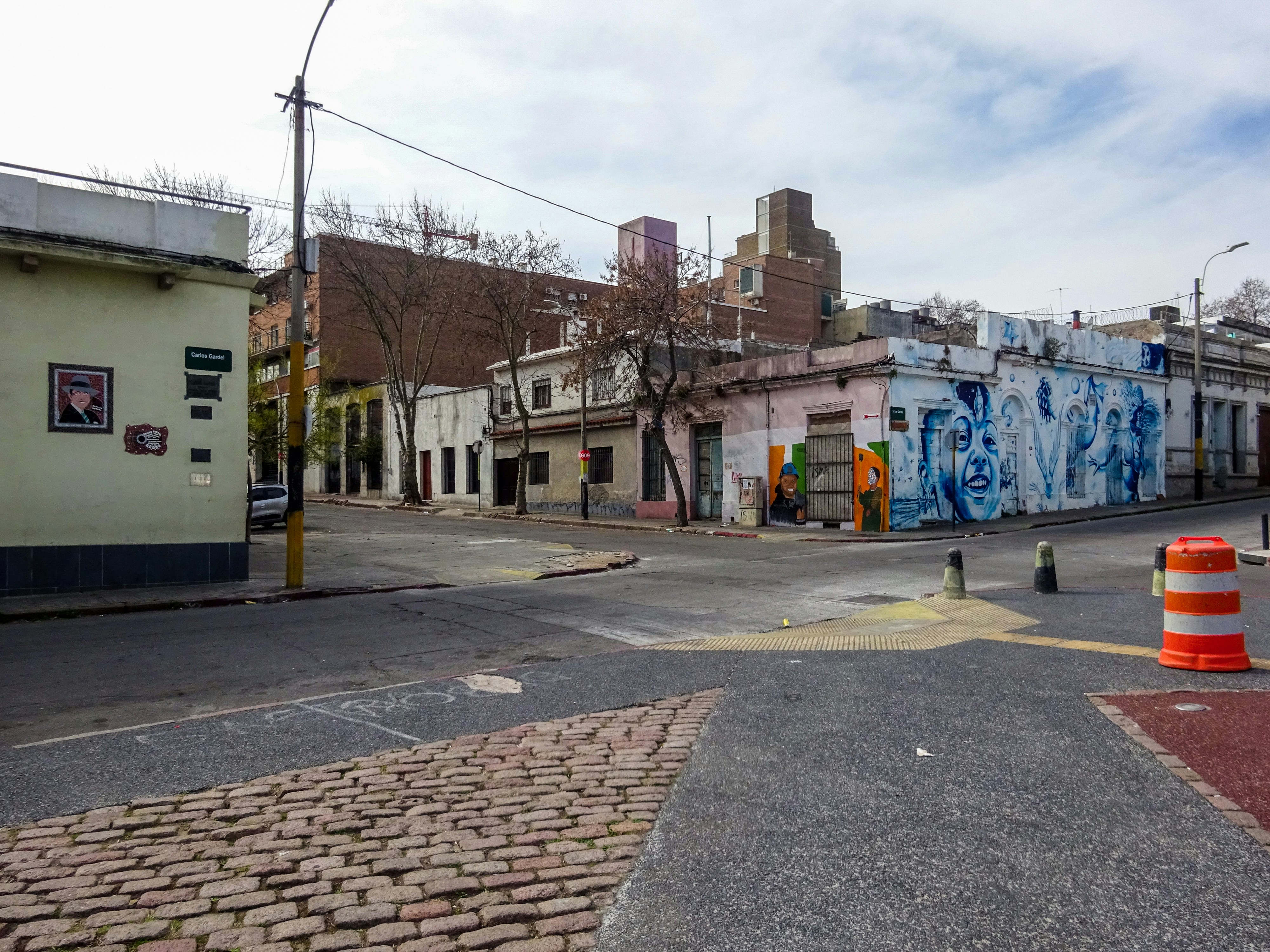 Urban Amalgam: Street Corner with Murals and Construction Orange